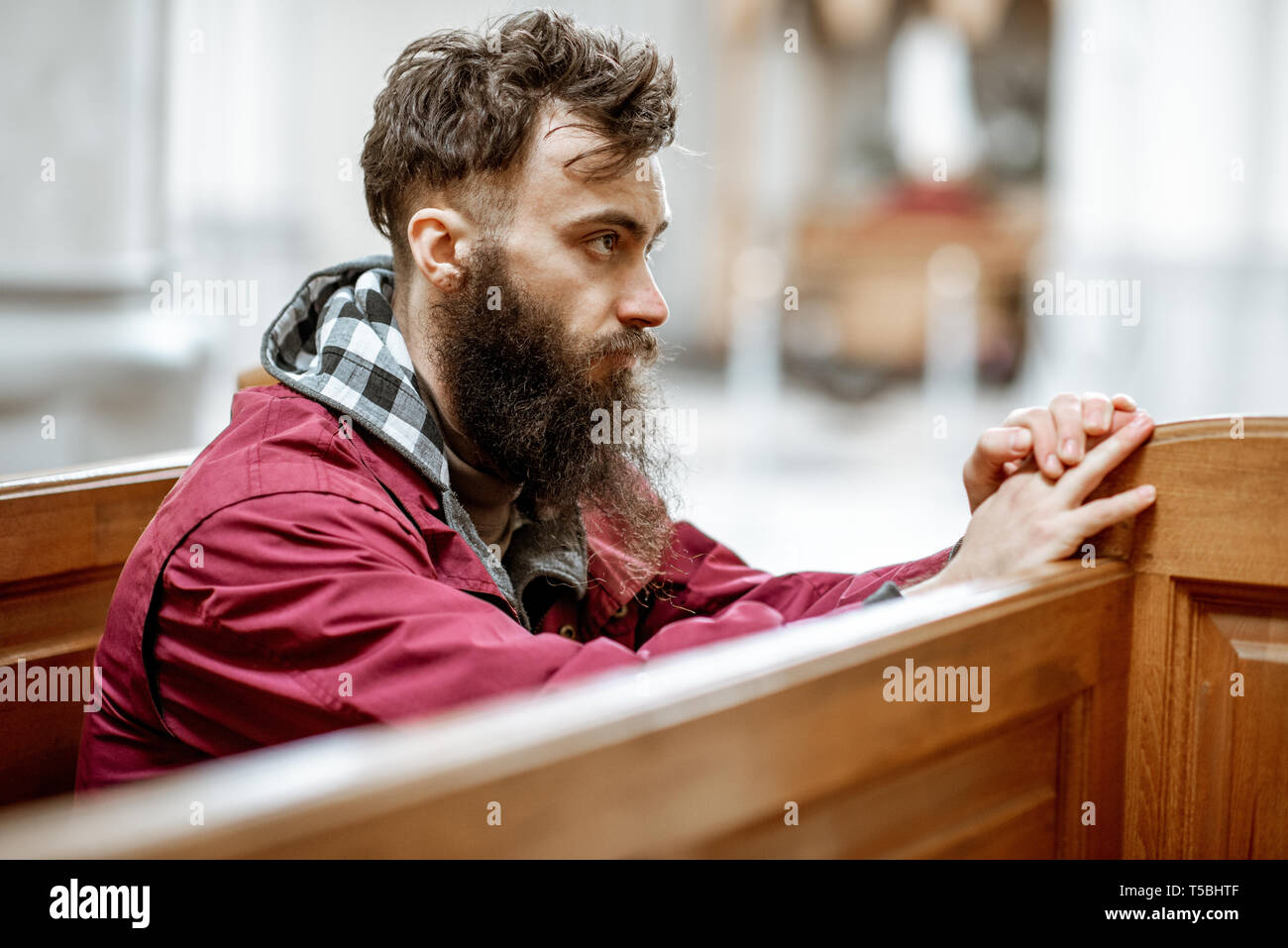 Bearded man praying to the god at the cathedral Stock Photo - Alamy