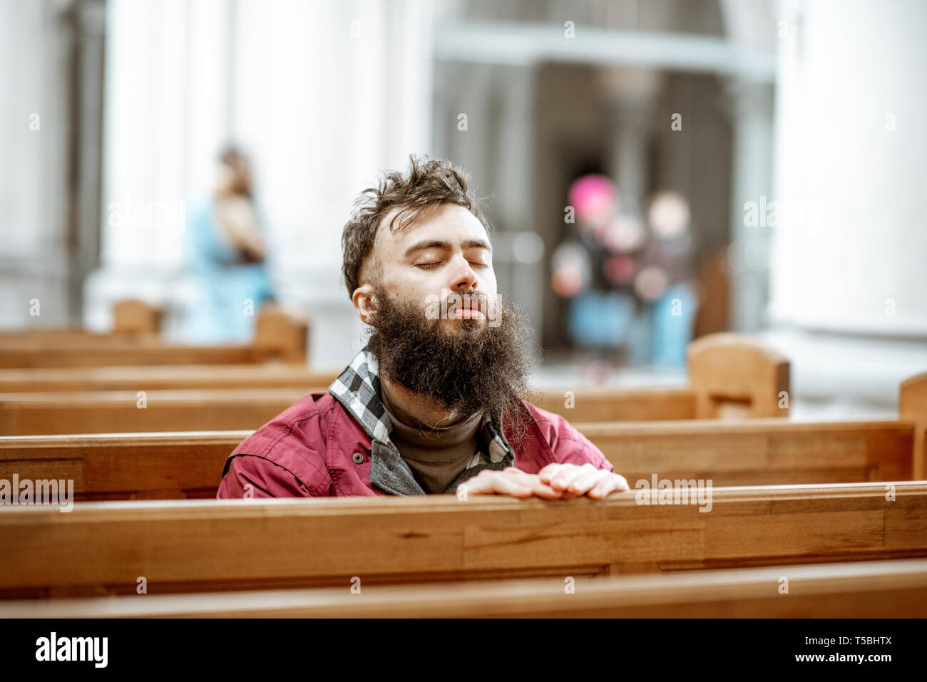 Bearded man praying to the god at the cathedral Stock Photo - Alamy