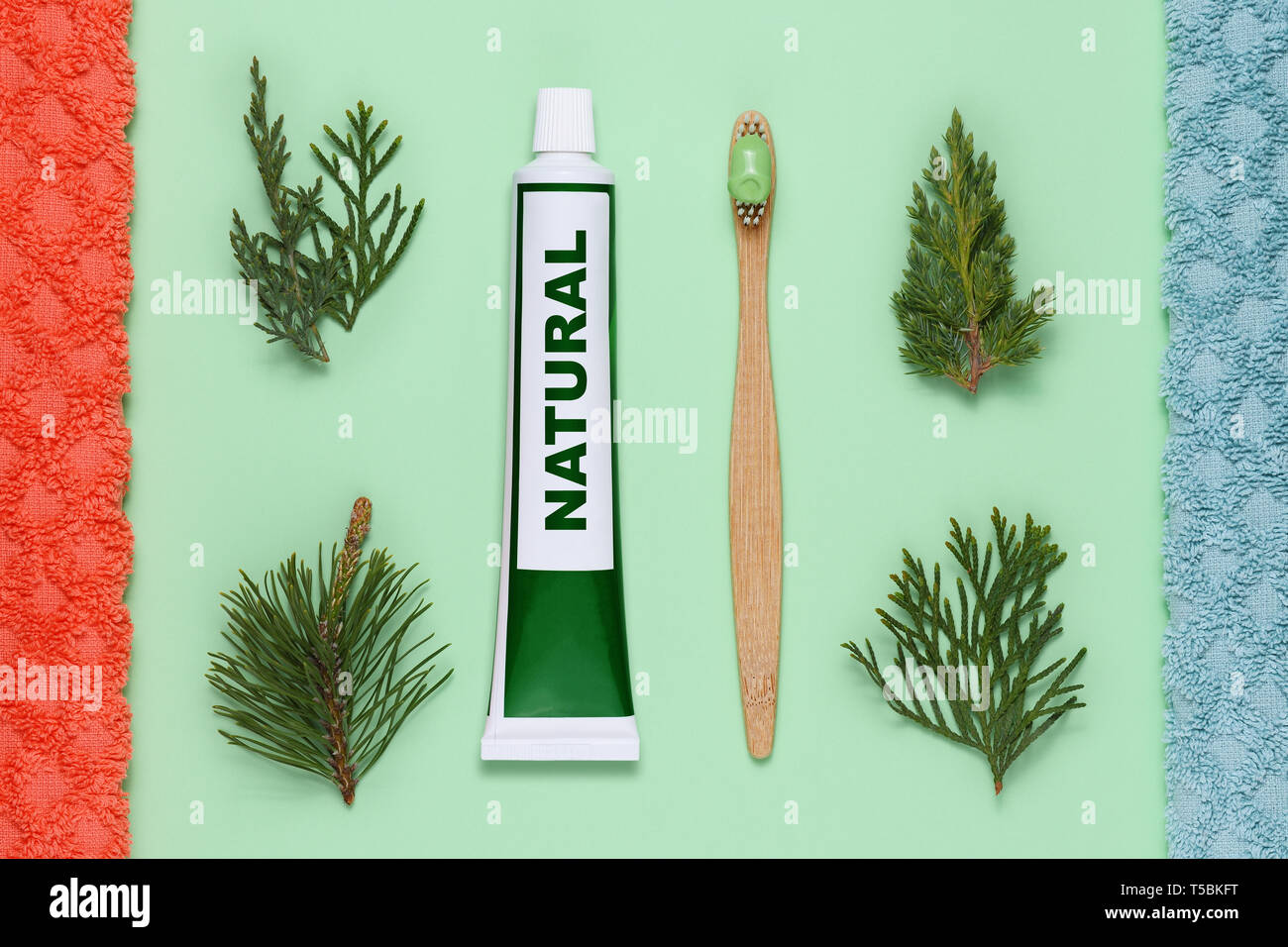 Tube of natural toothpaste and bamboo toothbrush on green background ...