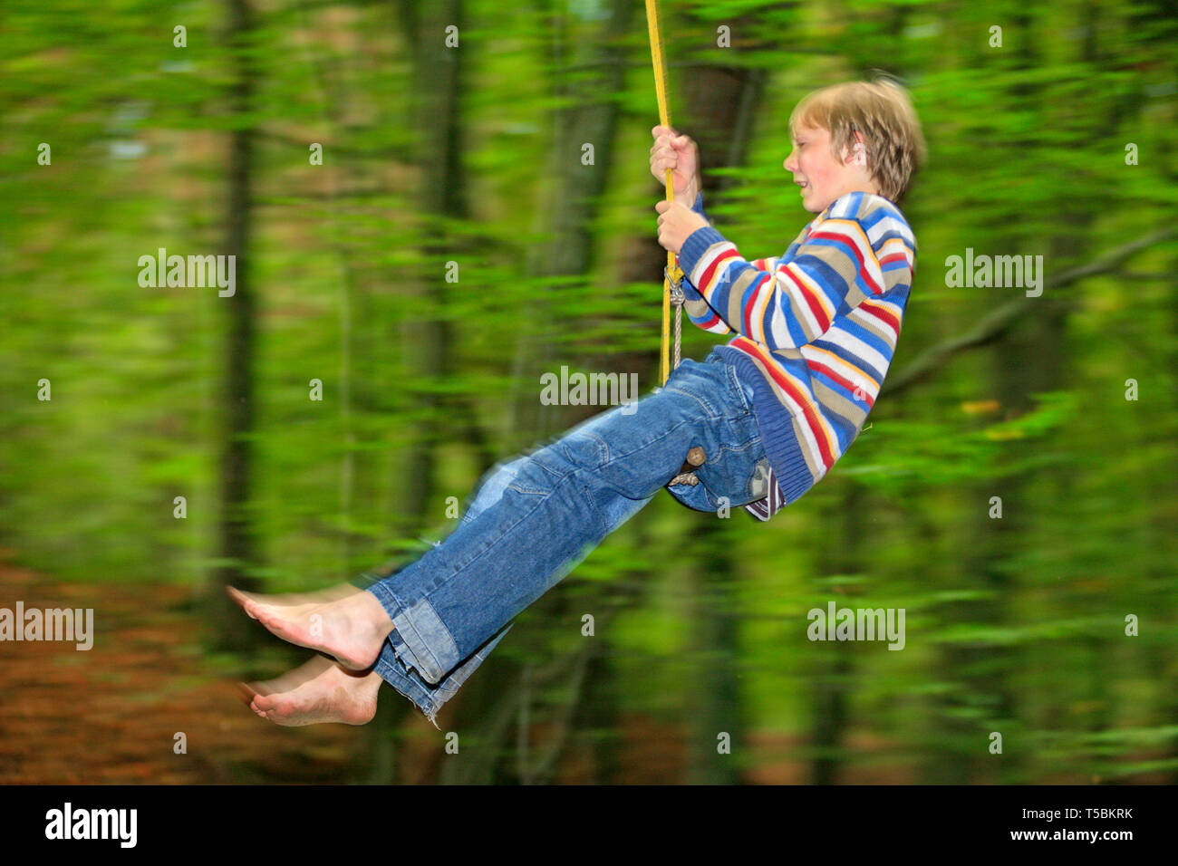 teenage boy swining on a rope Stock Photo - Alamy