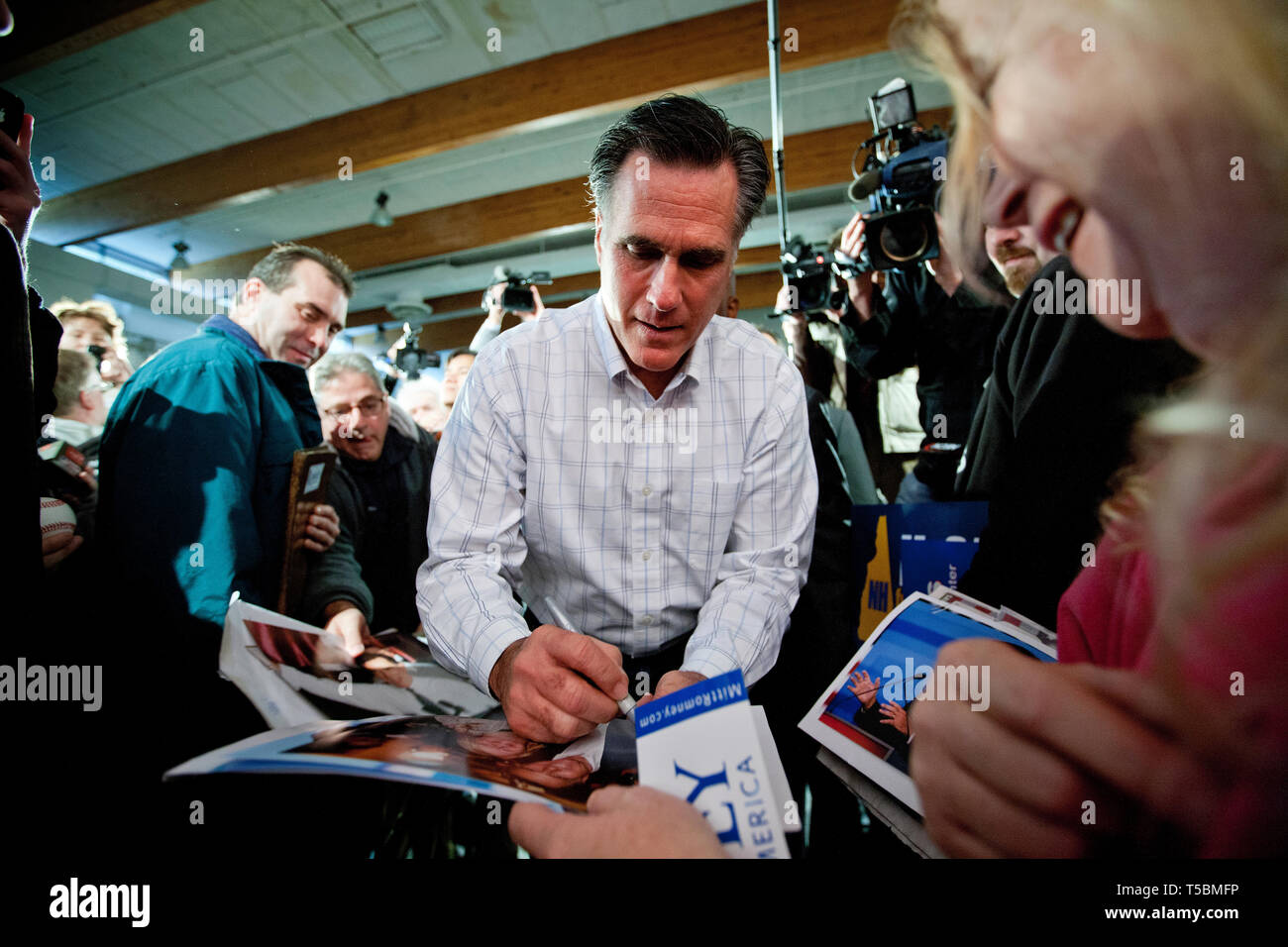 Presidential Hopeful Mitt Romney (R) signs his autograph on pictures ...