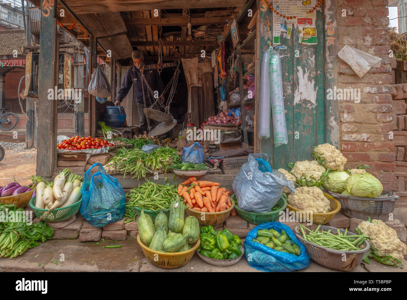 BHAKTAPUR, NEPAL - APRIL 5, 2019: Old man selling vegetable in an open ...