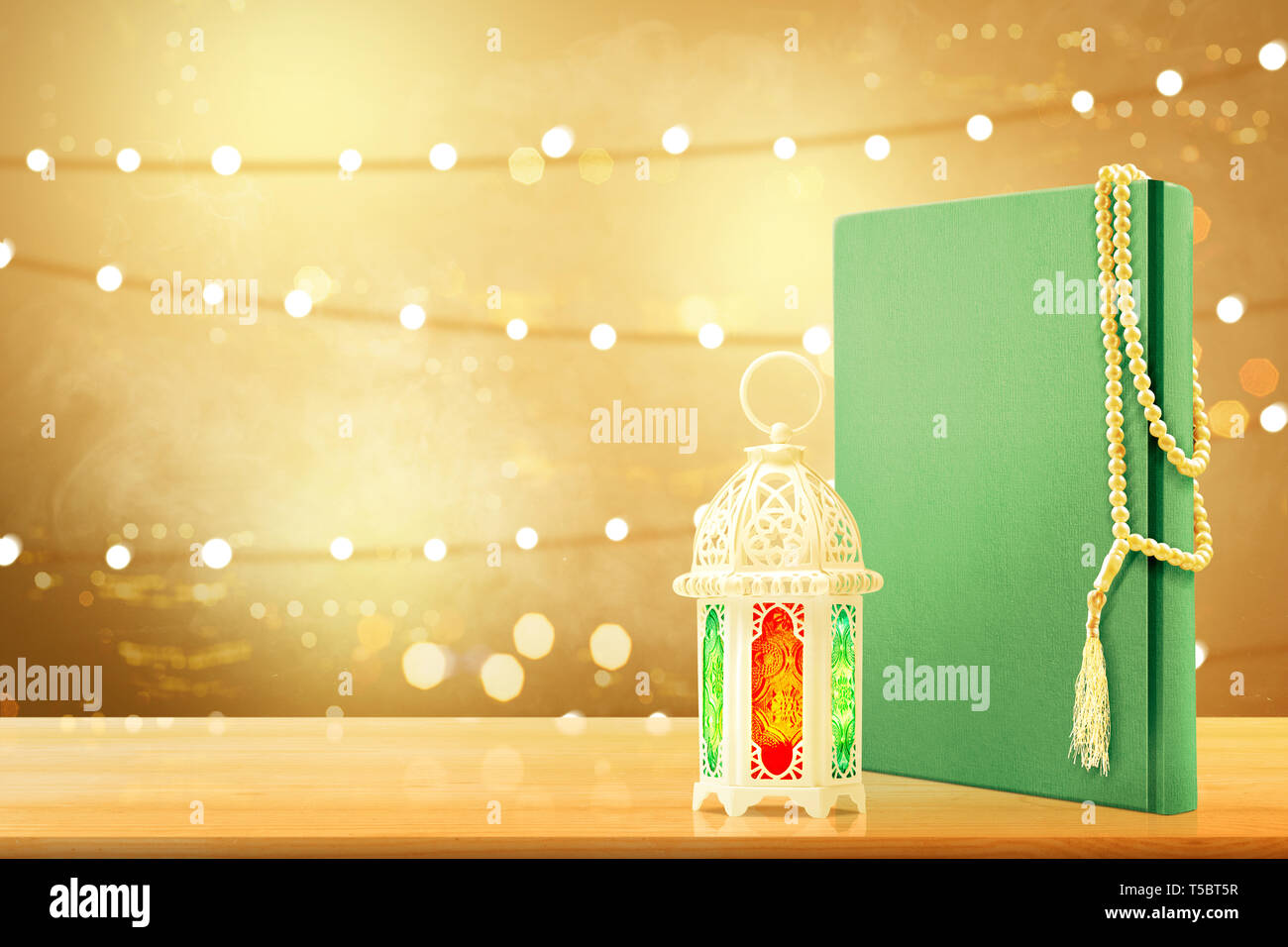 Quran with prayer beads and arabic lamp with beautiful light on wooden ...