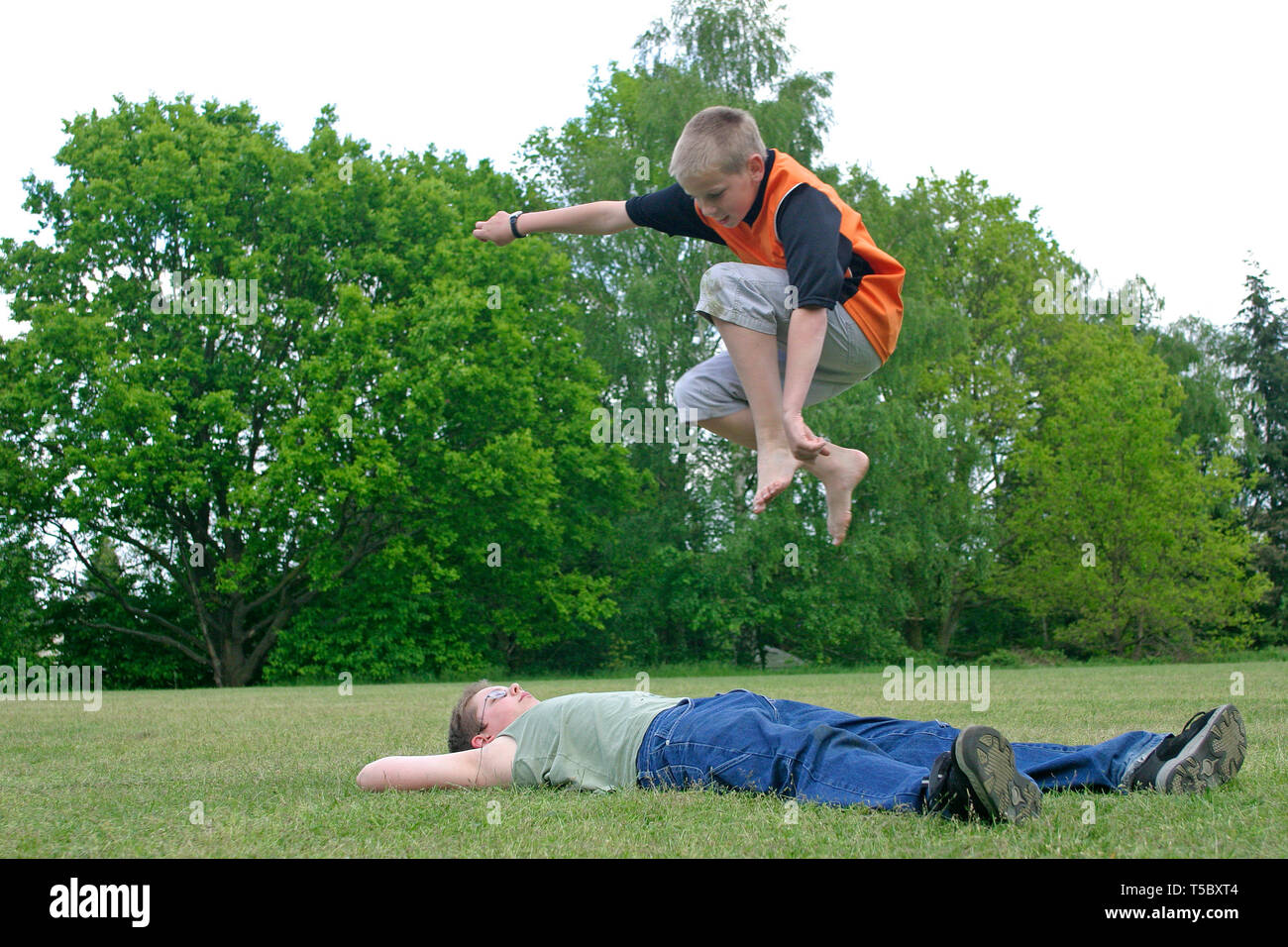 boy jumping across another one Stock Photo - Alamy