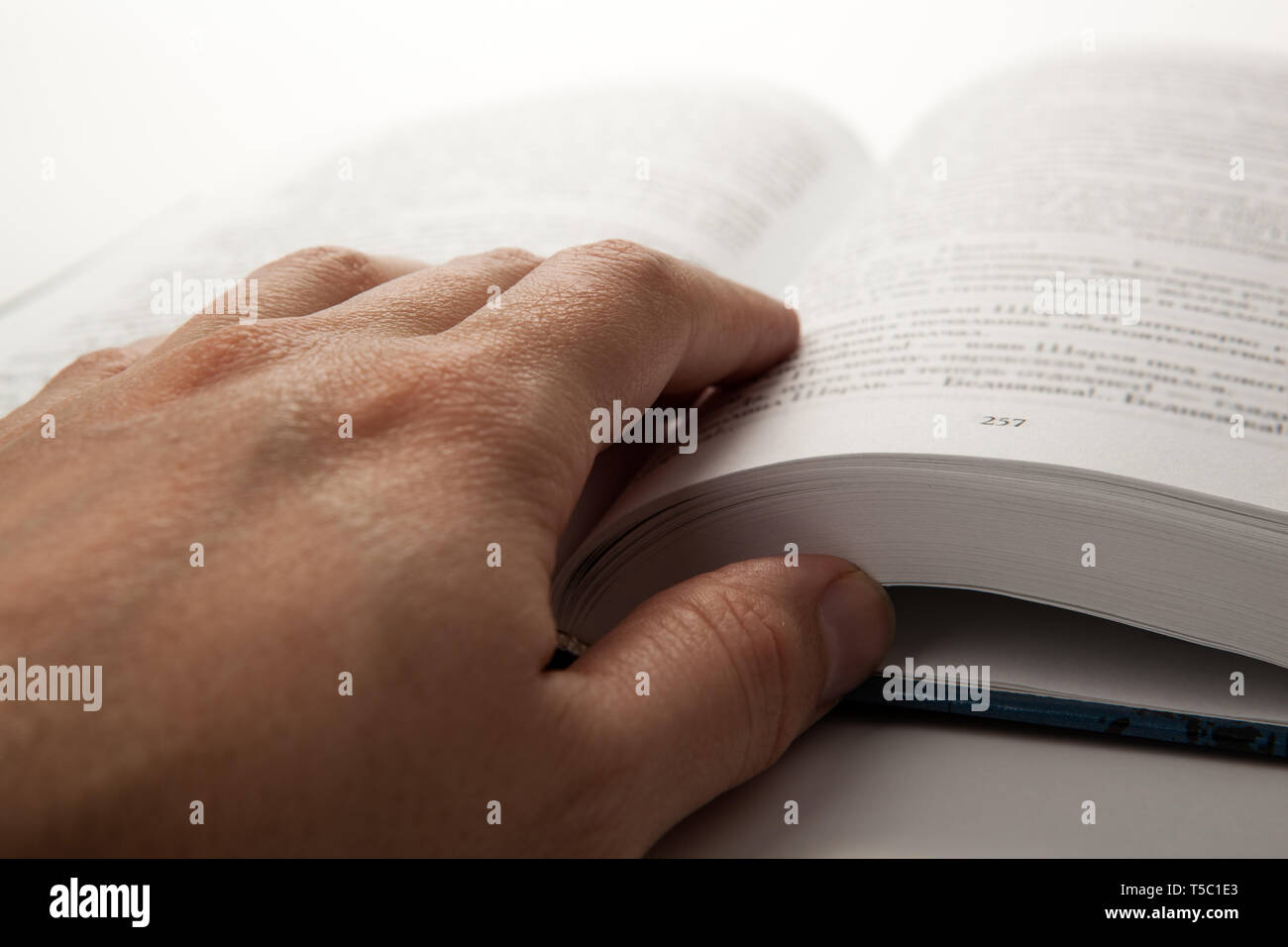 man's hand on an open book with white pages close up Stock Photo - Alamy