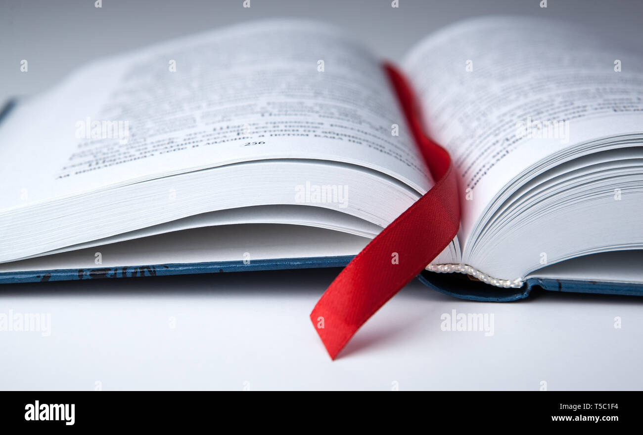new open book on a gray table with a red ribbon bookmark close up Stock ...