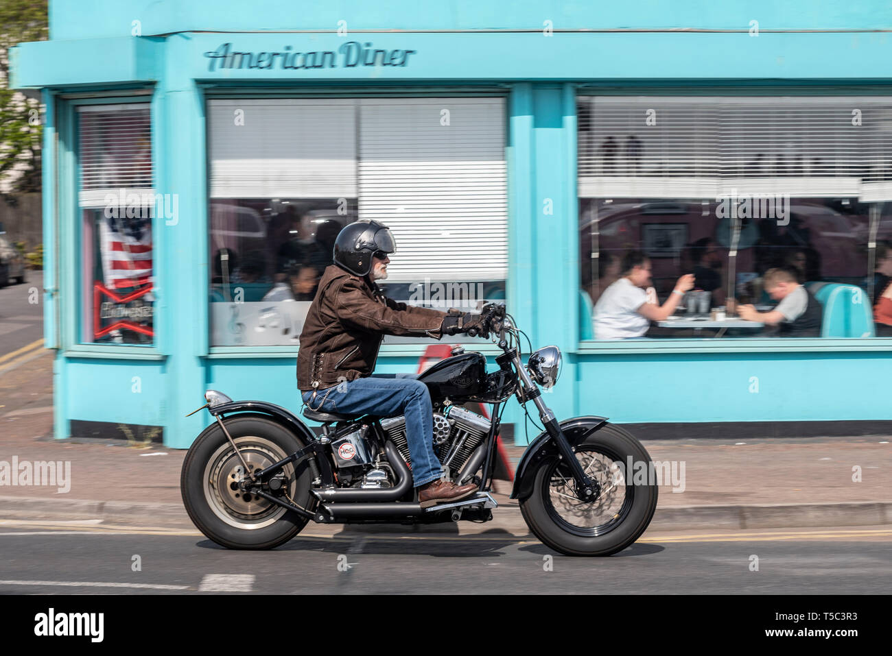 Harley Davidson Hog motorbike riding past an American Diner at the ...