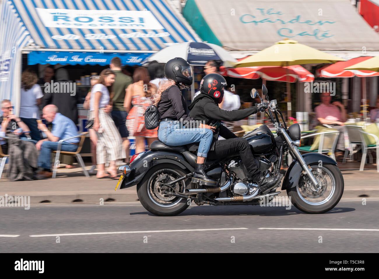 Black cruiser motorbike with female pillion ridden at the Southend ...