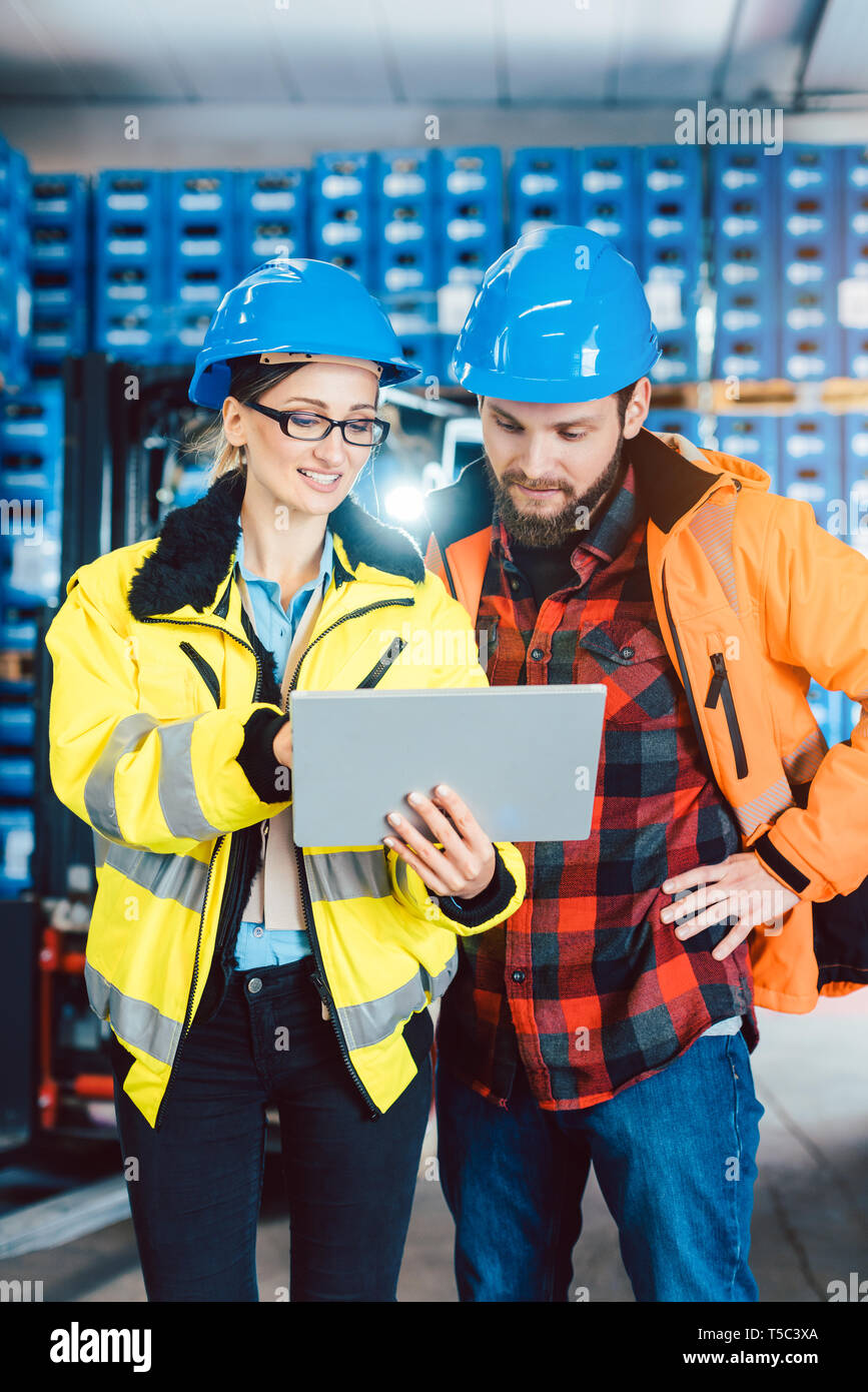 Woman and man as workers in logistics center using computer Stock Photo ...