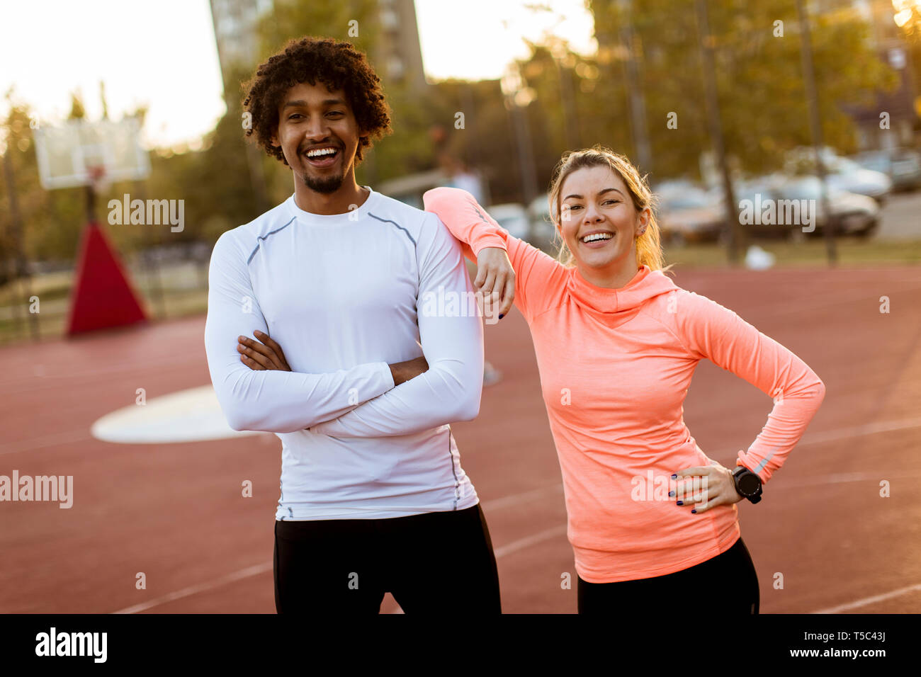 Portrait of multiracial couple of young runners resting after training ...