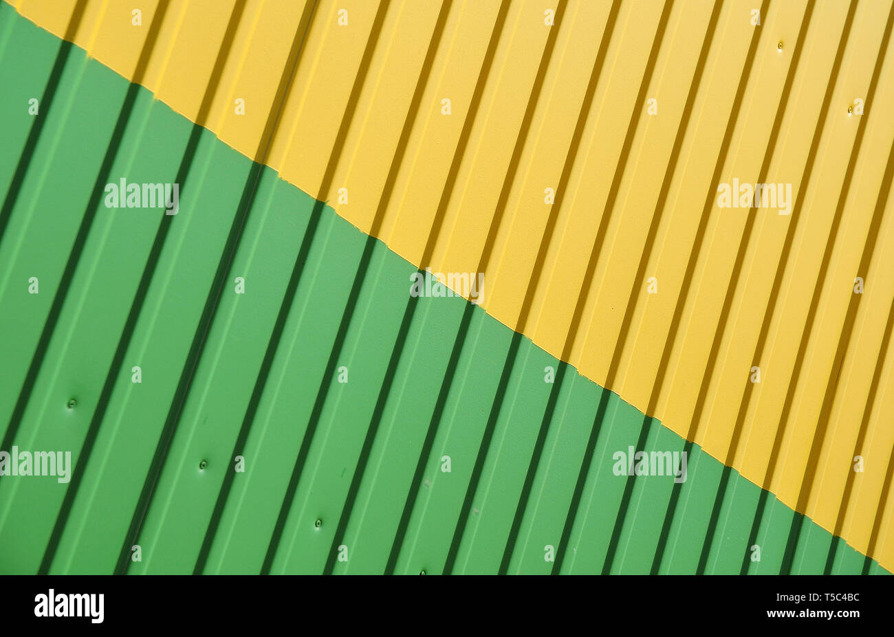 metal container with yellow and green painted wall Stock Photo - Alamy