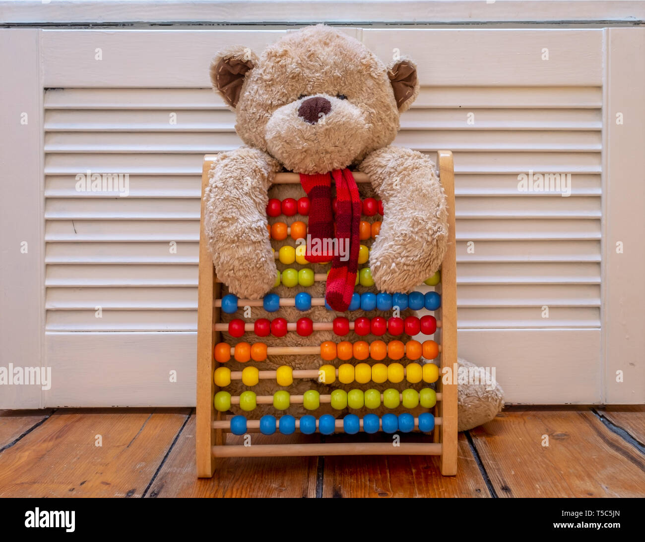Teddy bear holding a vintage colorful abacus Stock Photo - Alamy