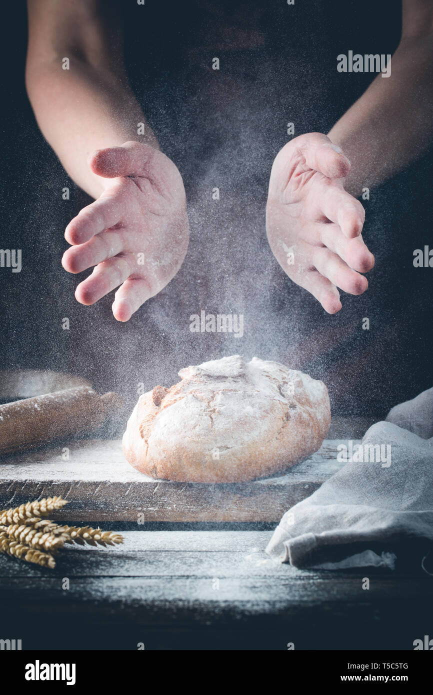 Baker cooking bread. Man slaps flour over the dough. Man's hands Making ...