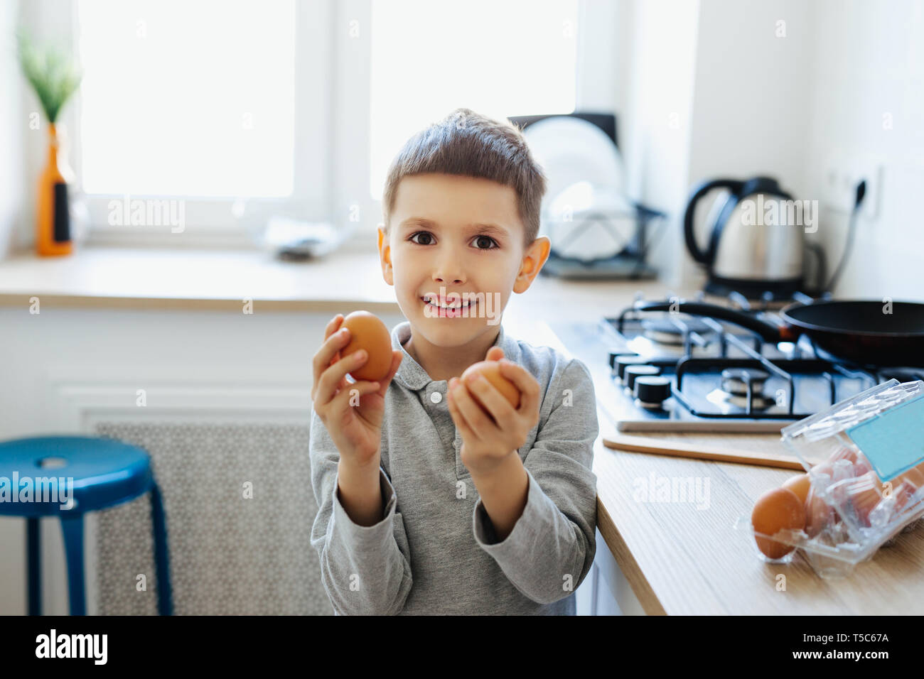 Preparation of family breakfast. Little son cook eggs in morning Stock ...