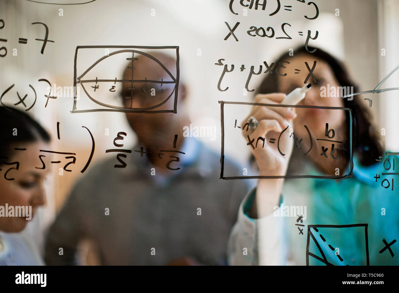 Mathmeticians working to solve equation Stock Photo - Alamy