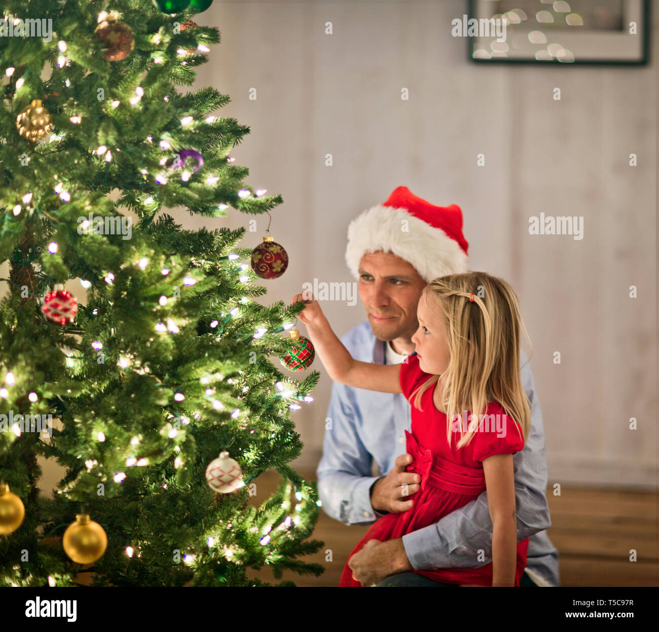 Father and daughter decorating the Christmas tree Stock Photo - Alamy