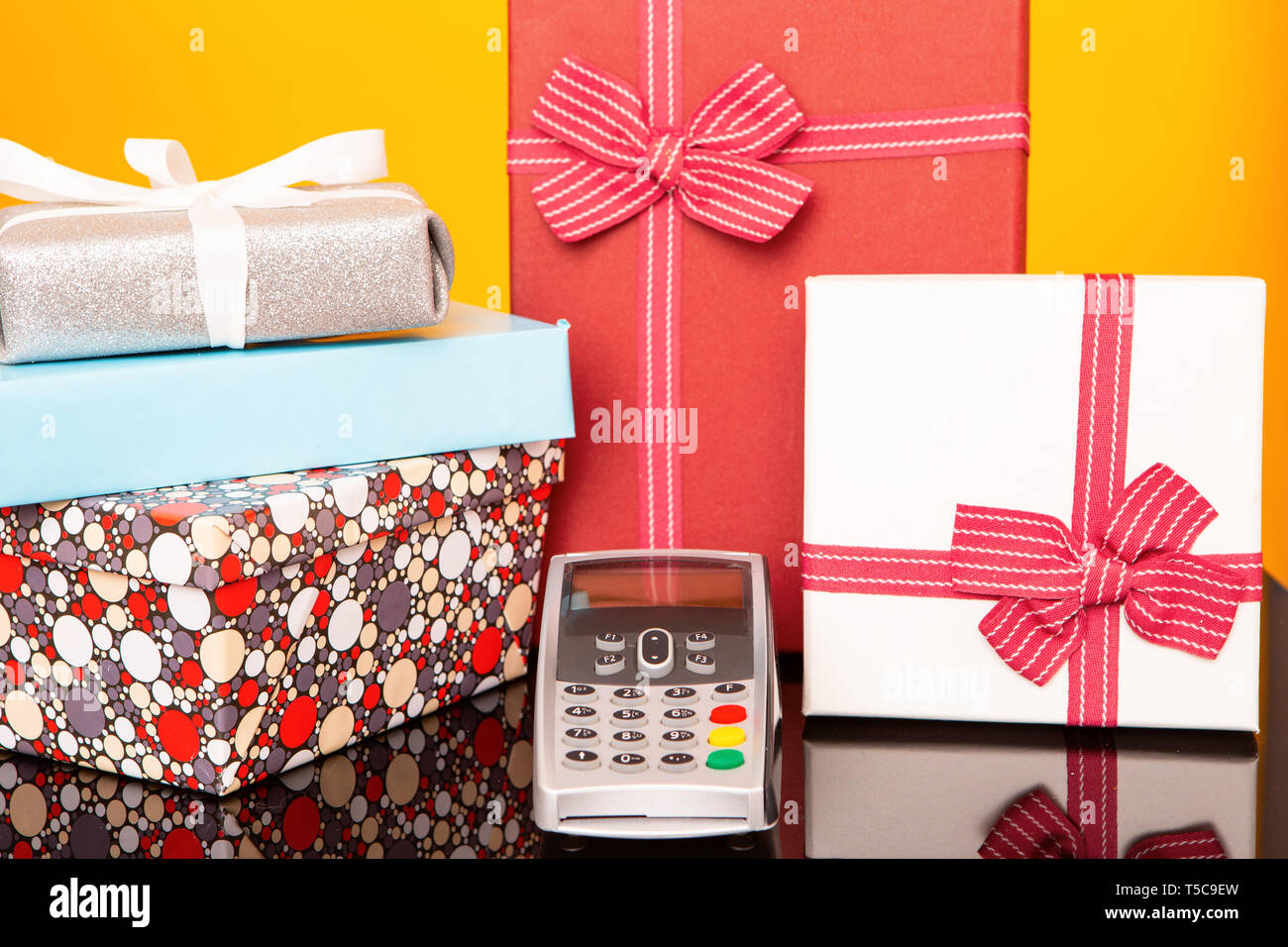 Terminal, boxes with gifts on black glass table and yellow background ...