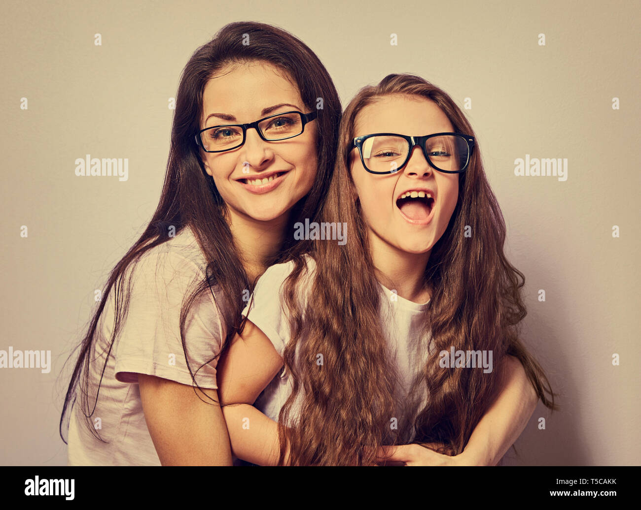 Happy young casual mother and smiling crazy kid in fashion glasses ...