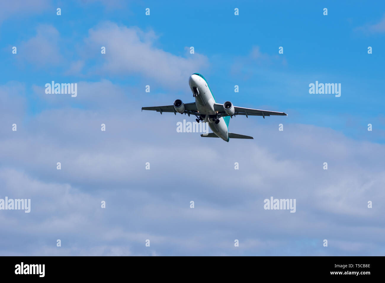 Airplane in flight viewed from the ground, with clouds Stock Photo - Alamy