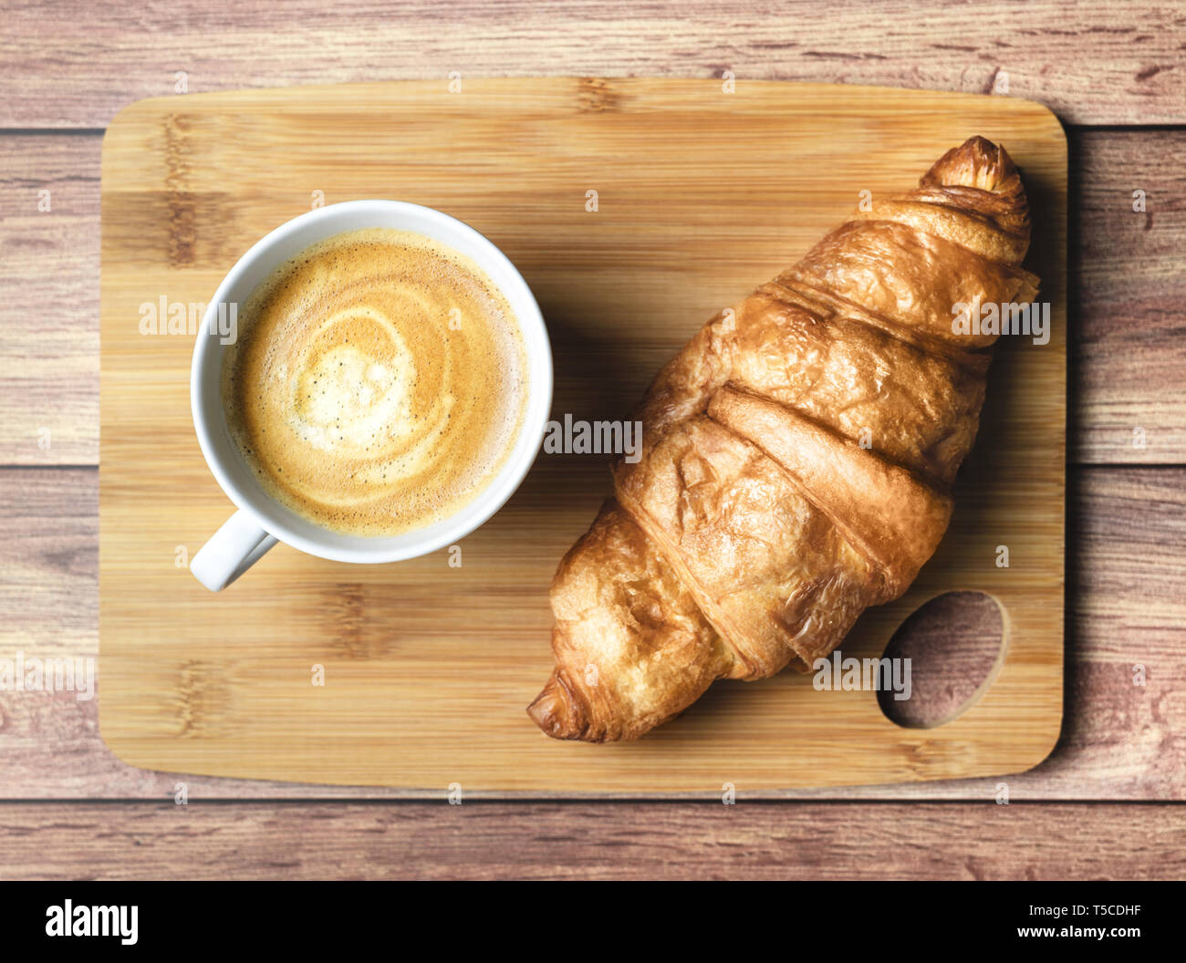 Perfect breakfast of croissant and coffee on wooden table. Rustic style ...