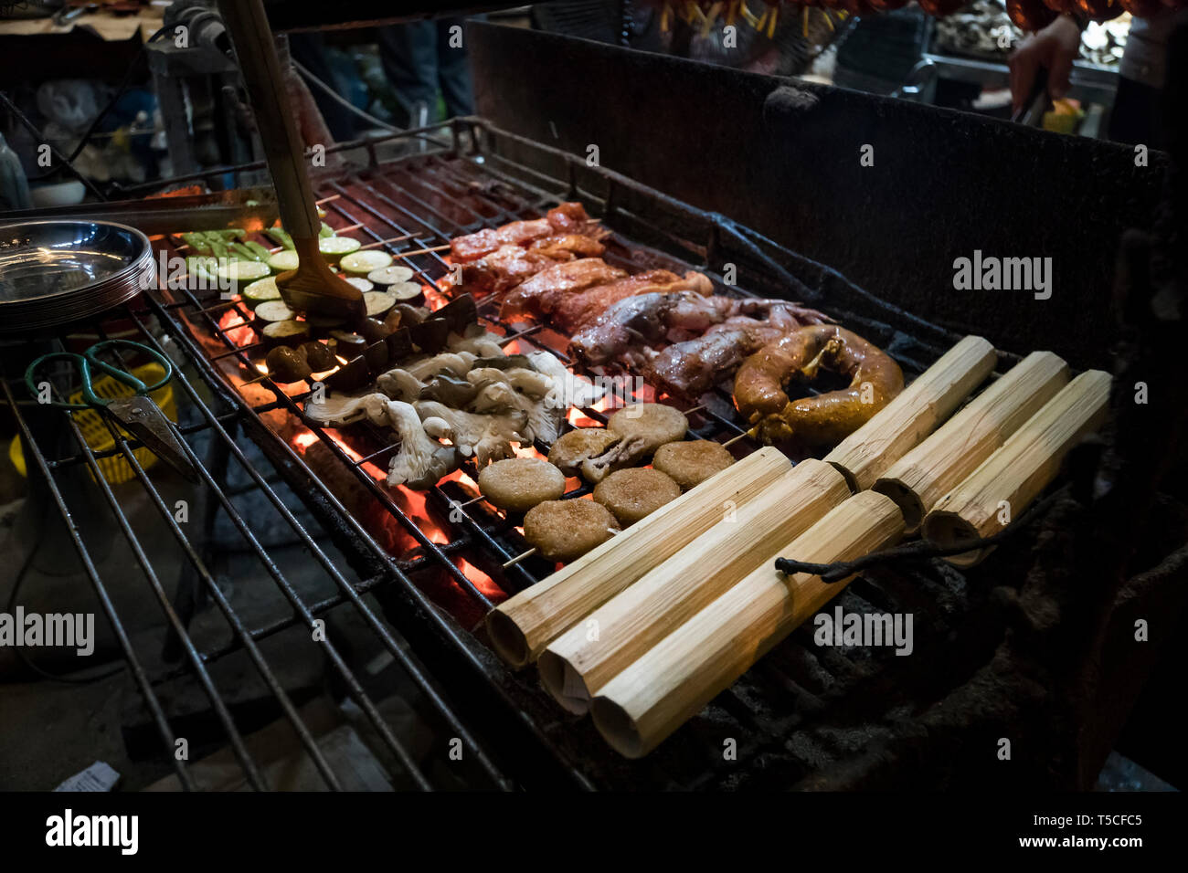 Seafood kebab, vegetables, meat, rice baked in bamboo are cooked on the ...