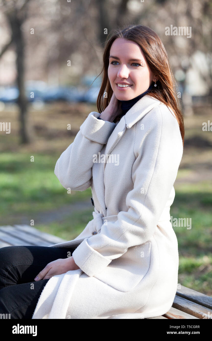 Pretty girl sitting on a bench in a city park Stock Photo - Alamy