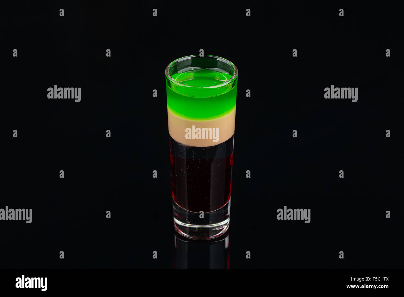Green alcoholic shot glass with absent, irish cream, liquor on elegant ...