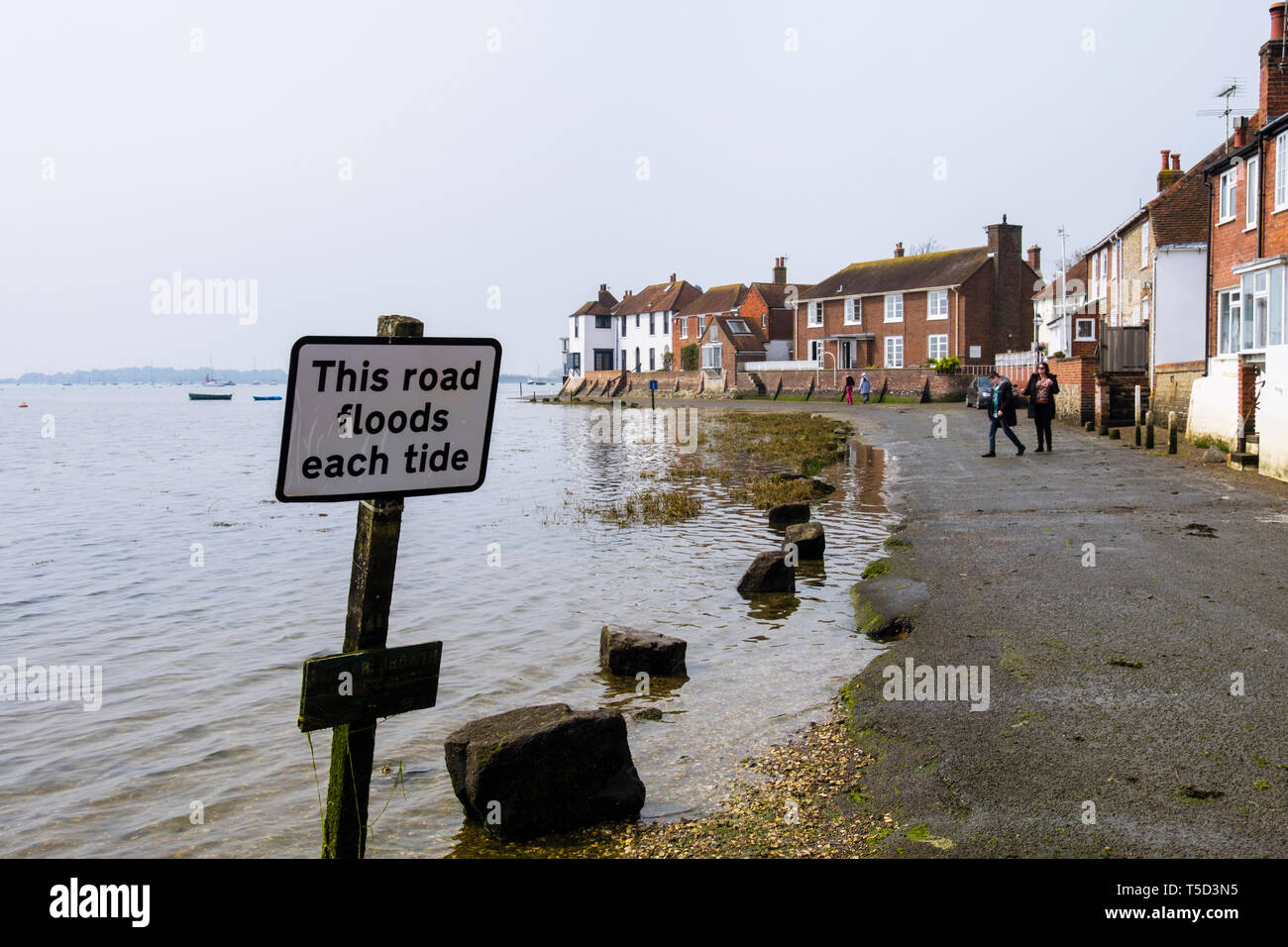 Road floods warning sign on seafront as tides goes out from Bosham ...