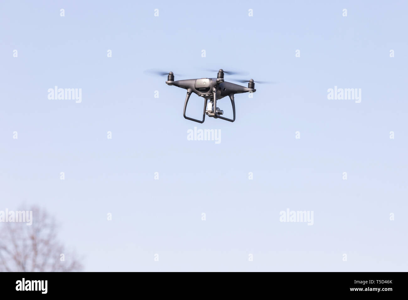 Flying drone on the blue sky. Modern silver drone flying Stock Photo ...