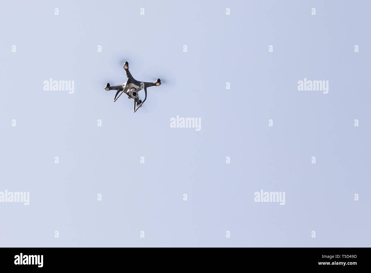 Flying drone on the blue sky. Modern silver drone flying Stock Photo ...