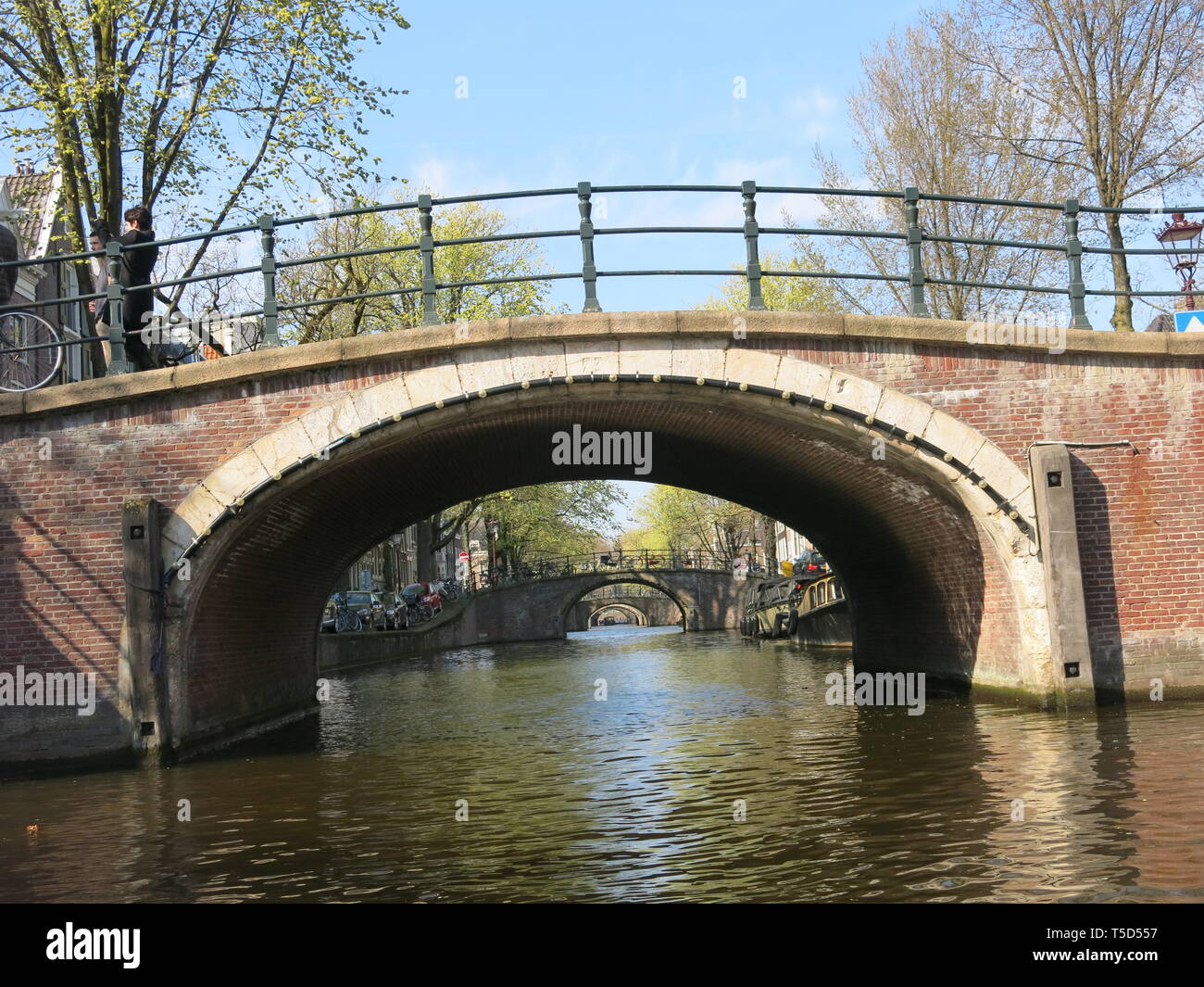 View under a canal bridge in Amsterdam with a series of further canal ...
