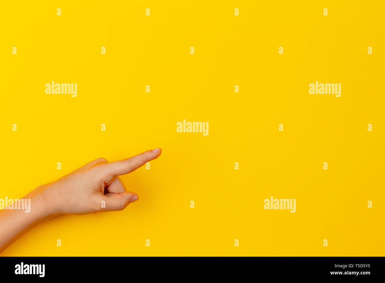 Kid hands pointing to something on yellow background Stock Photo - Alamy