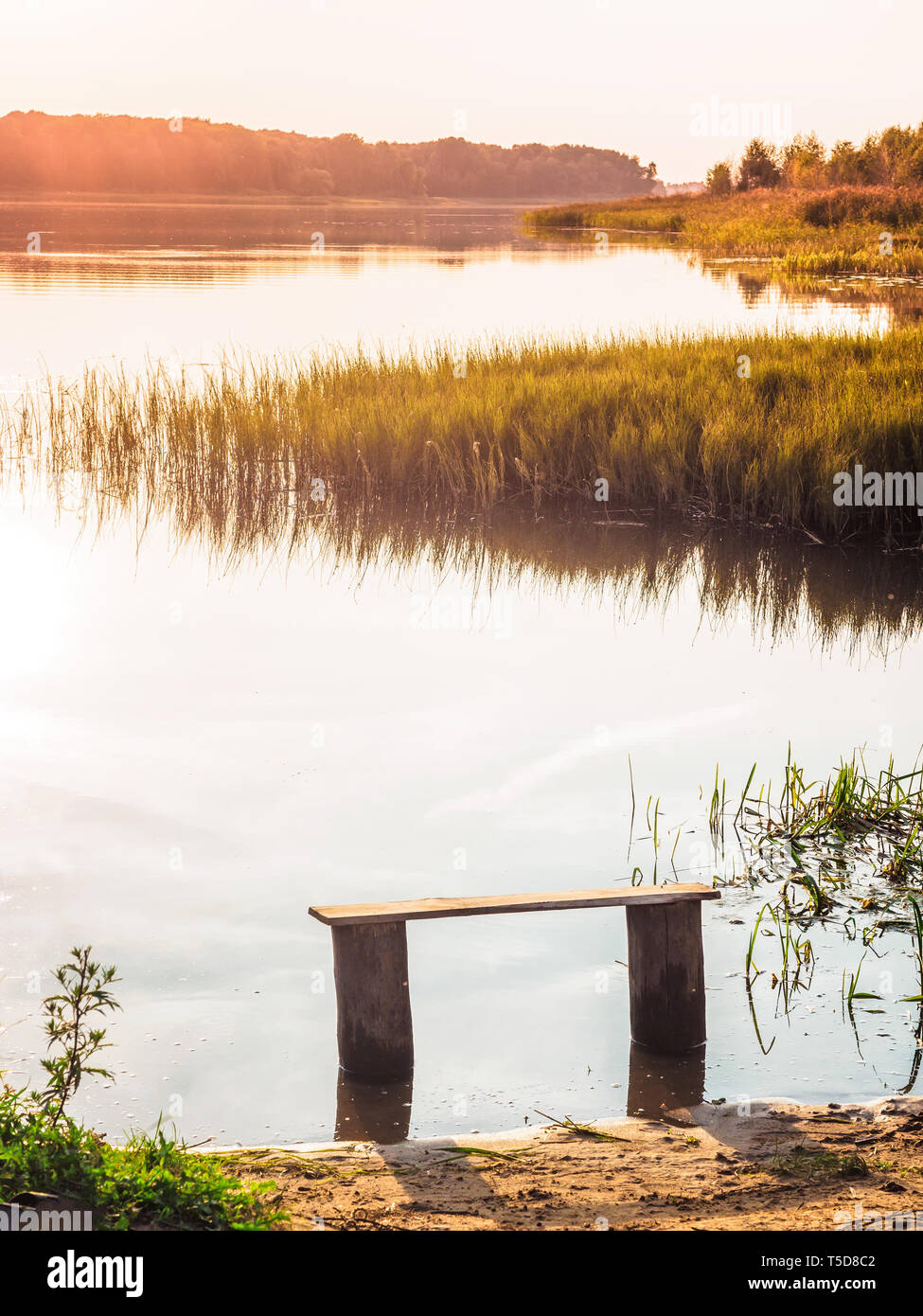 Empty bench near the river at sunset. Away from the hustle and bustle ...