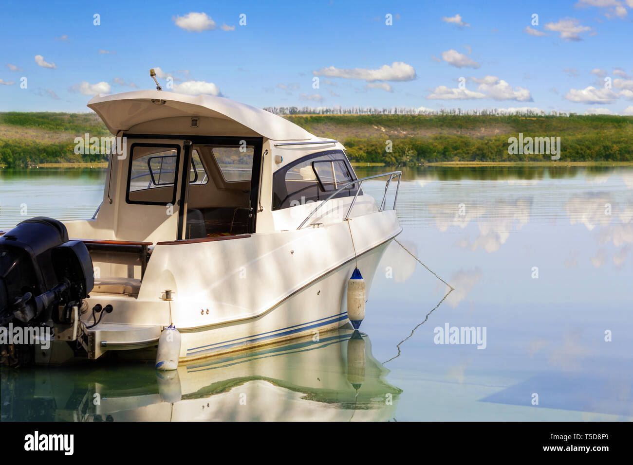 Big luxury fishing boat with cabin moored near river or lake shore in ...