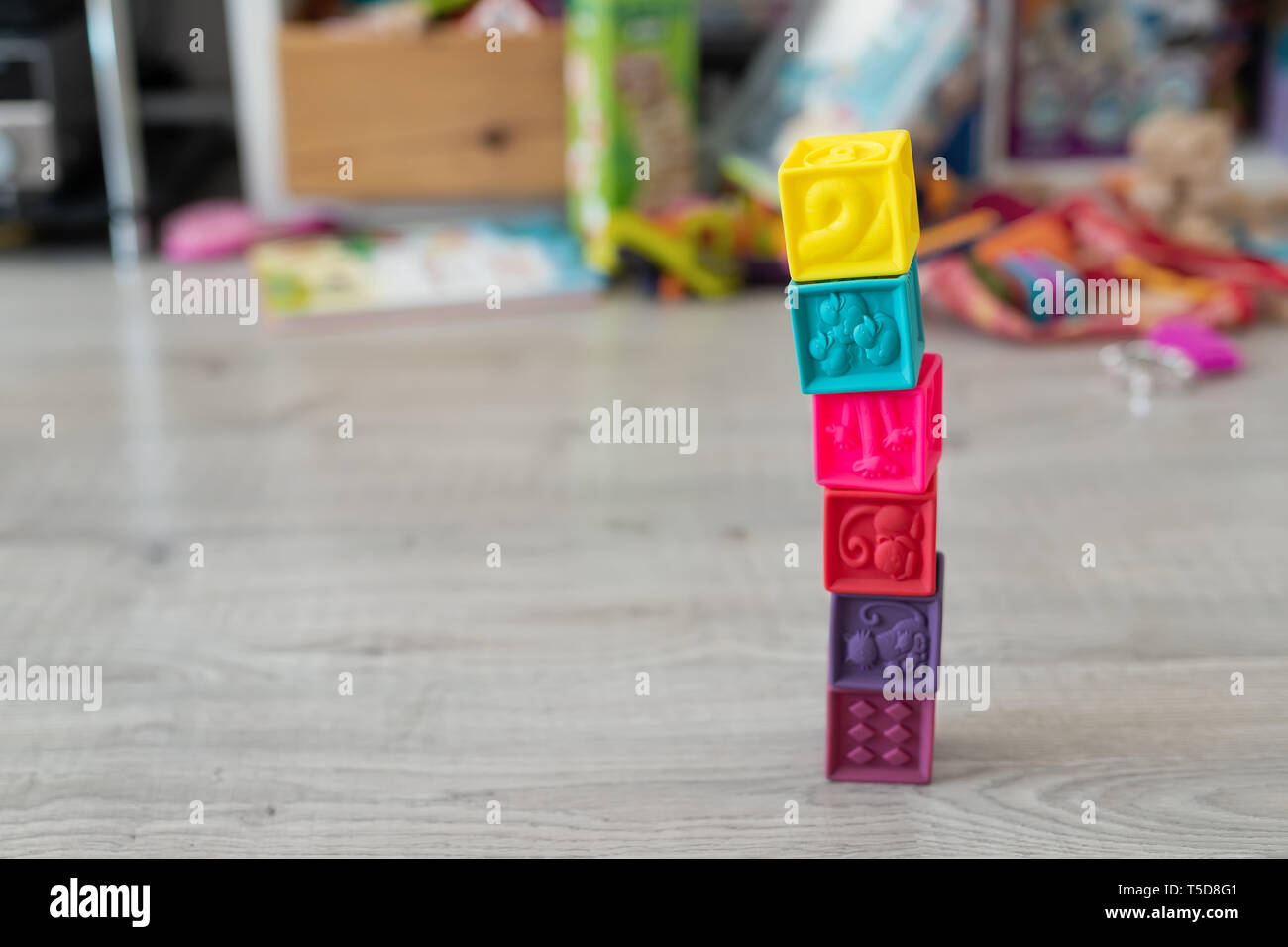 Colorful toys and disorder on floor at home. Tower of soft rubber cubes ...