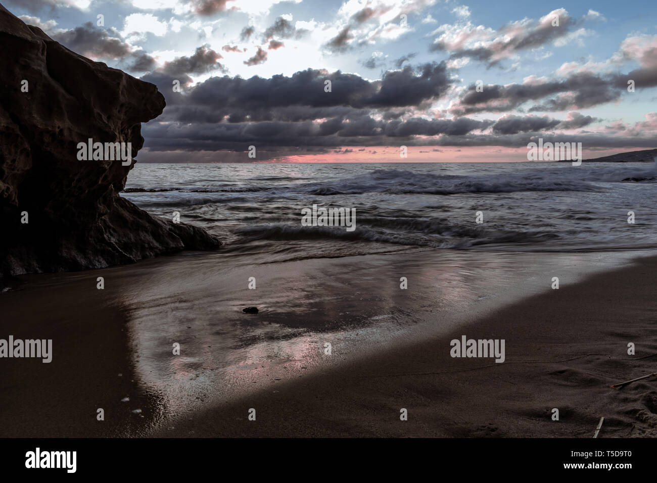 Pacific shoreline with silky smooth water rolling in and out with the ...