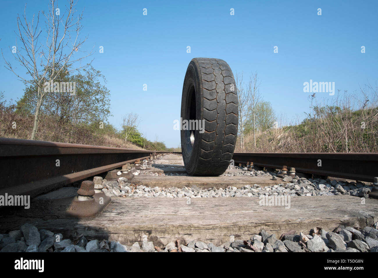 Big rubber truck tyre standing up on a railroad track Stock Photo - Alamy