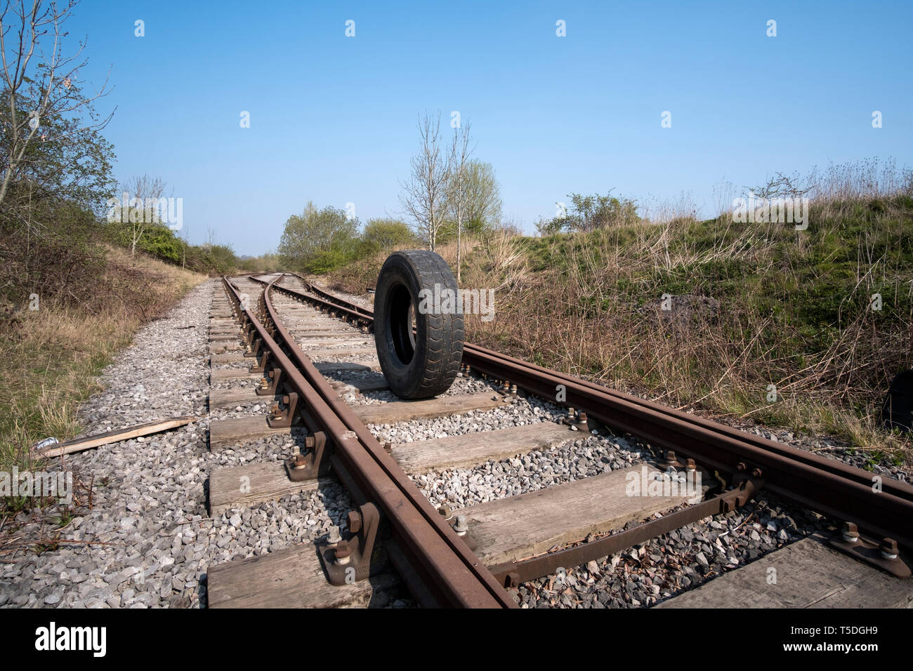 Old rubber lorry tyre in the middle of a railway track Stock Photo - Alamy