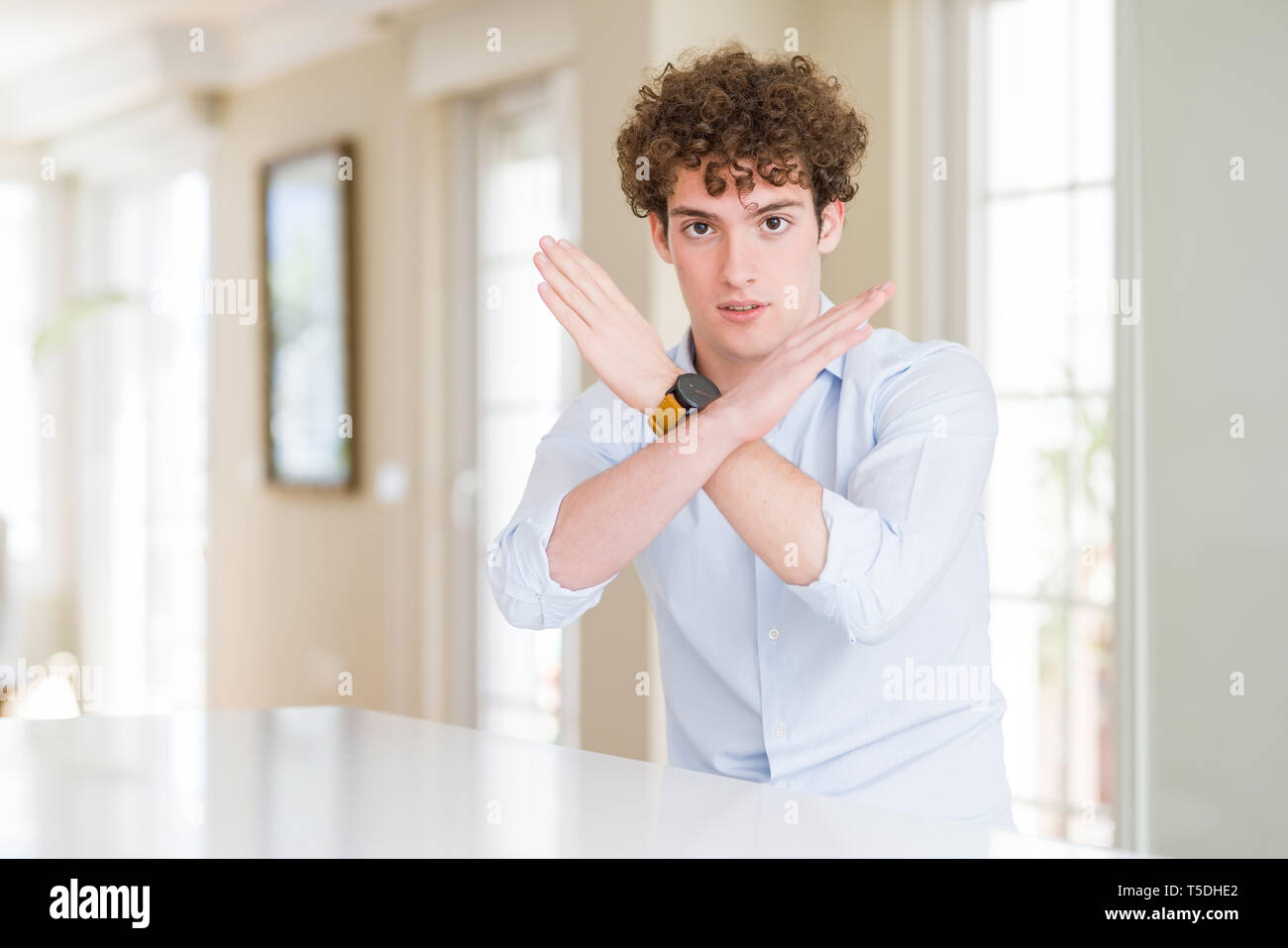 Young business man with curly read head Rejection expression crossing ...