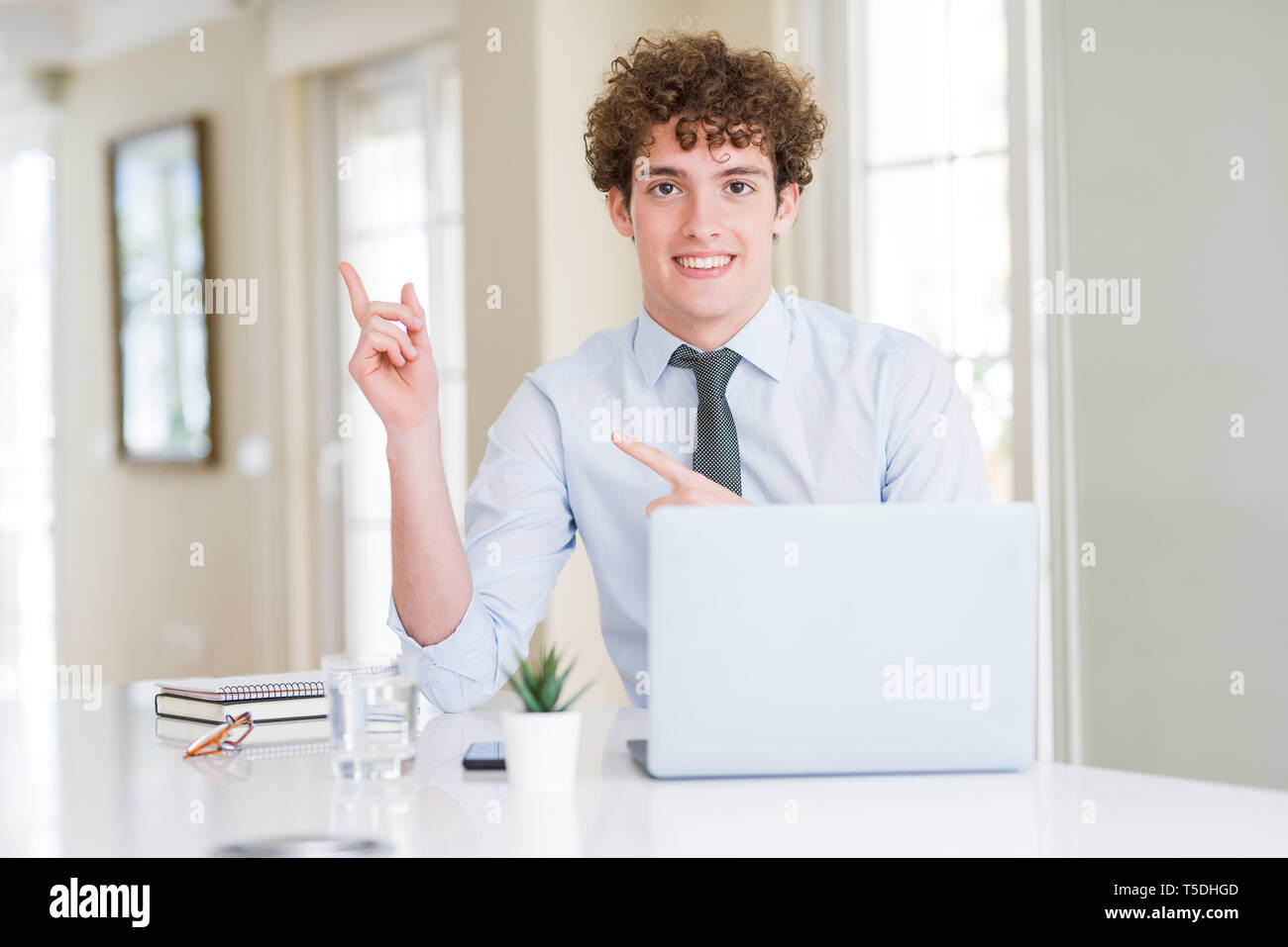 Young business man working with computer laptop at the office smiling ...