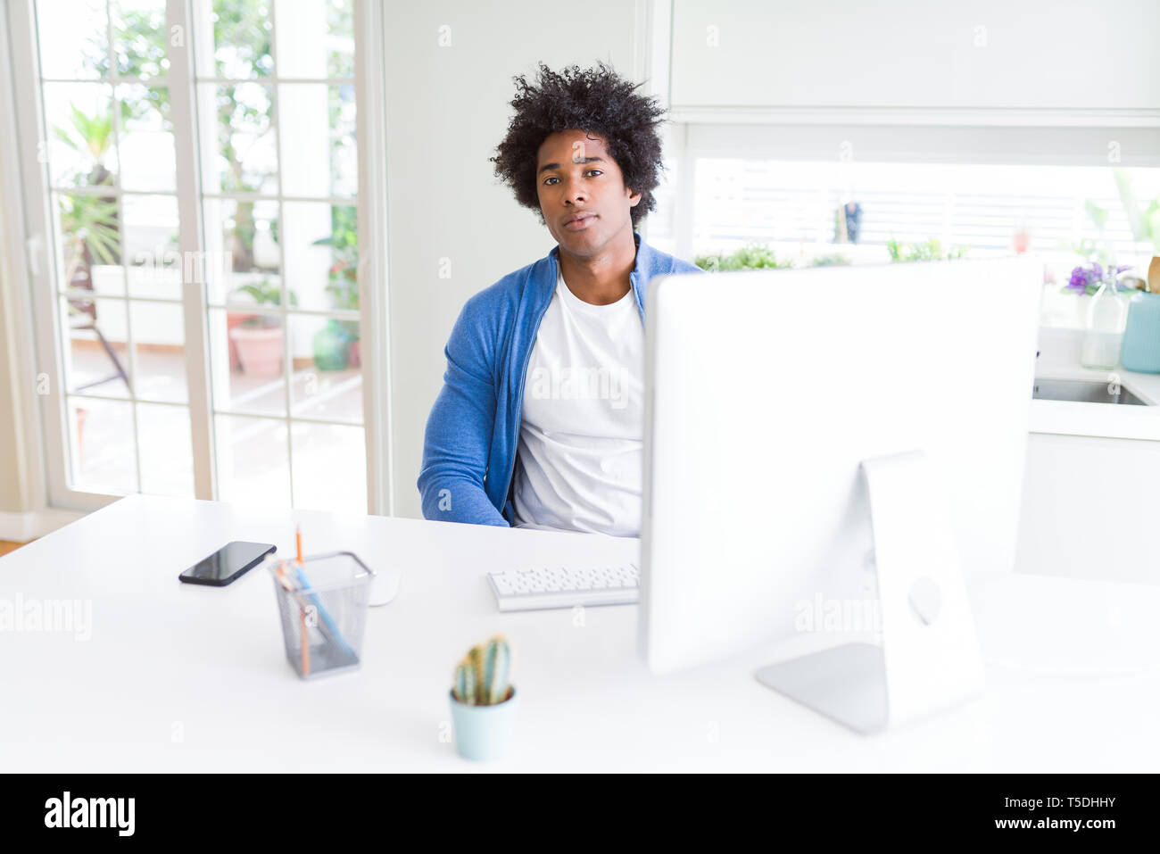 African American man working using computer with serious expression on ...