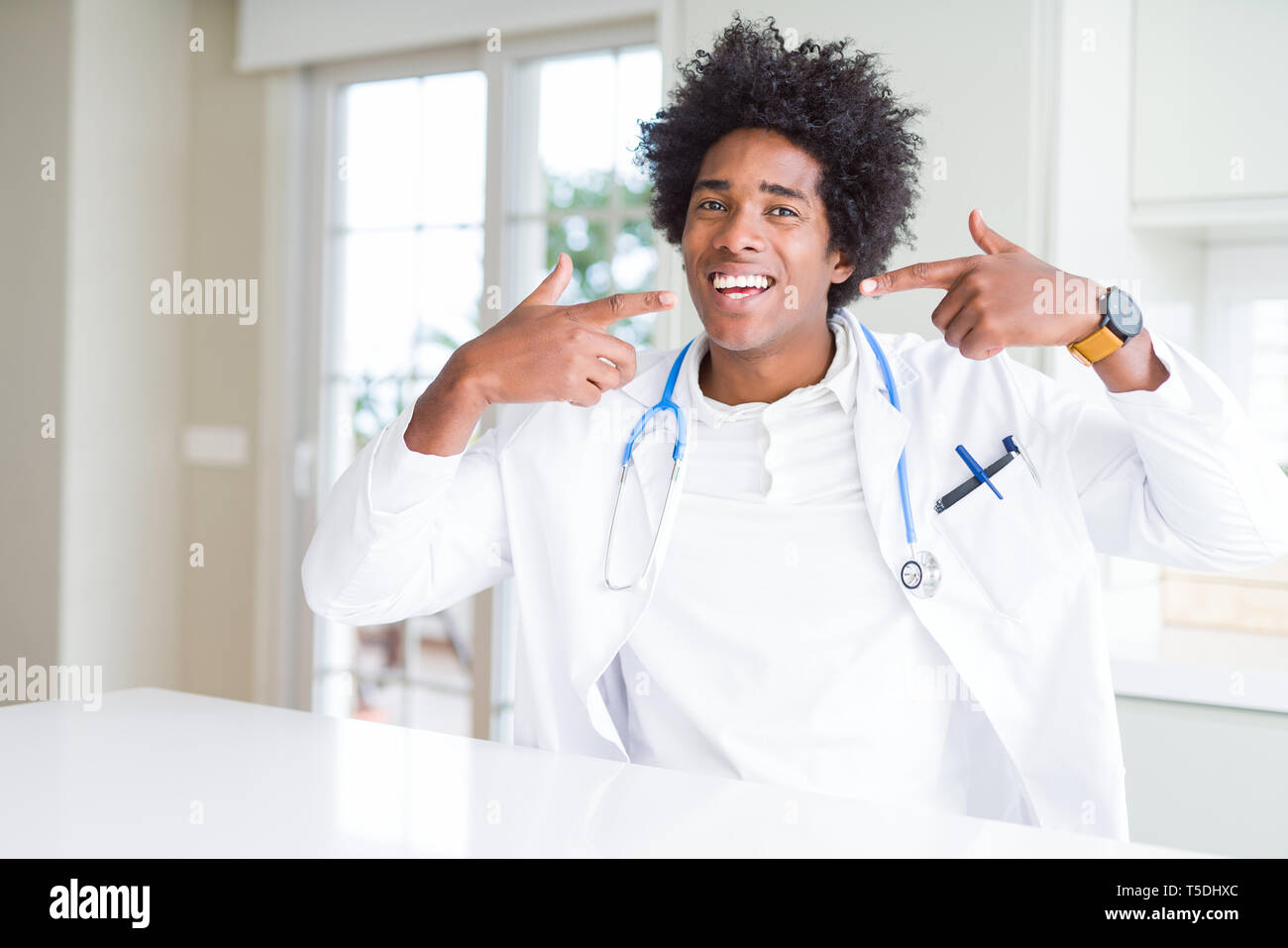 African American doctor man at the clinic smiling confident showing and ...