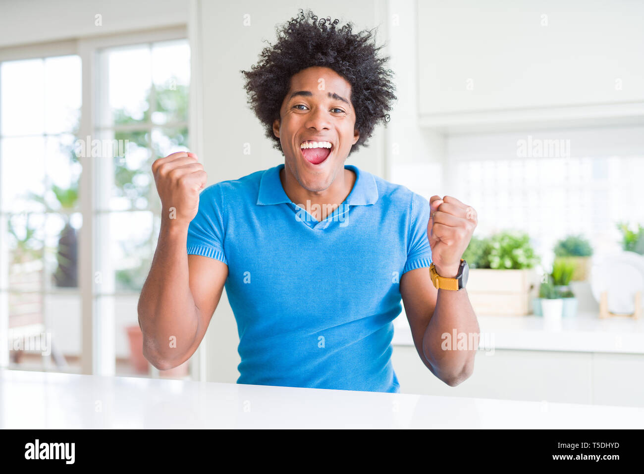 African American man at home very happy and excited doing winner ...