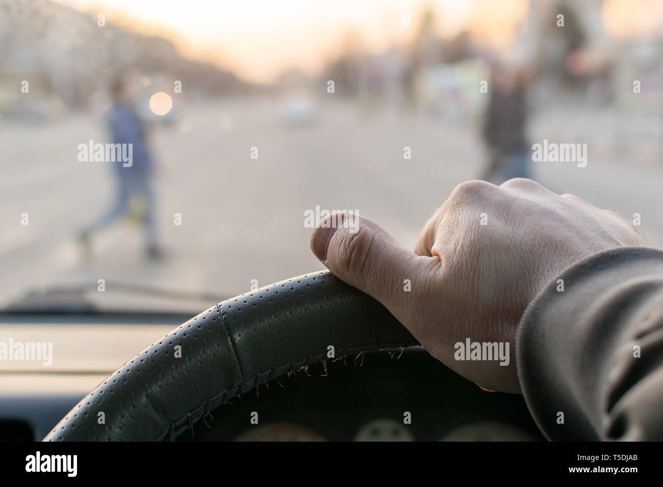 view from the car, the man's hand on the steering wheel of the car ...