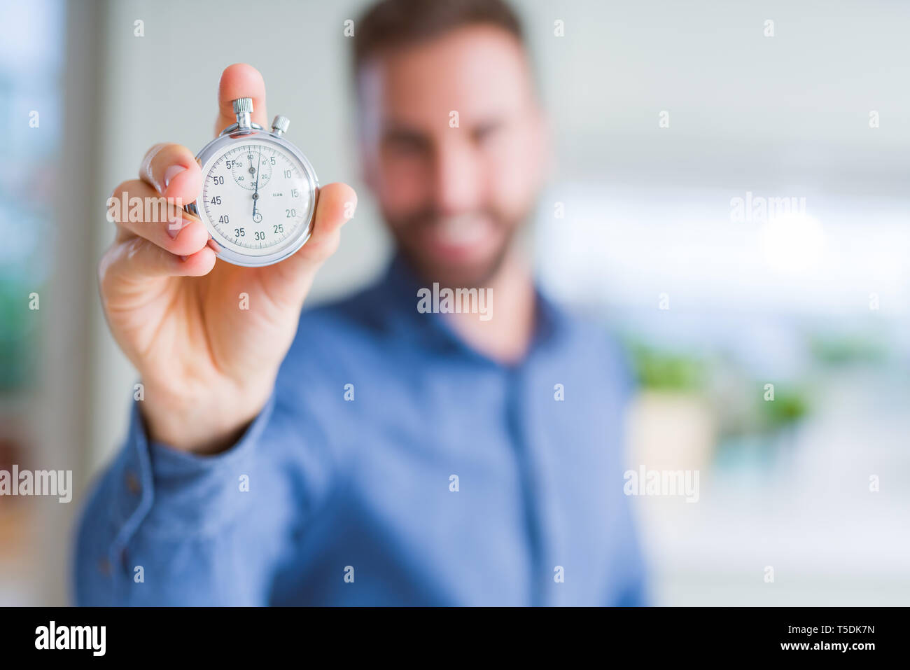 Handsome man showing stopwatch Stock Photo - Alamy