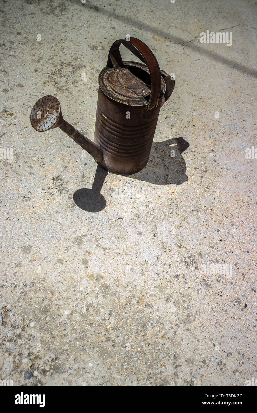 old and rusted flowerpot watering can isolated Stock Photo - Alamy