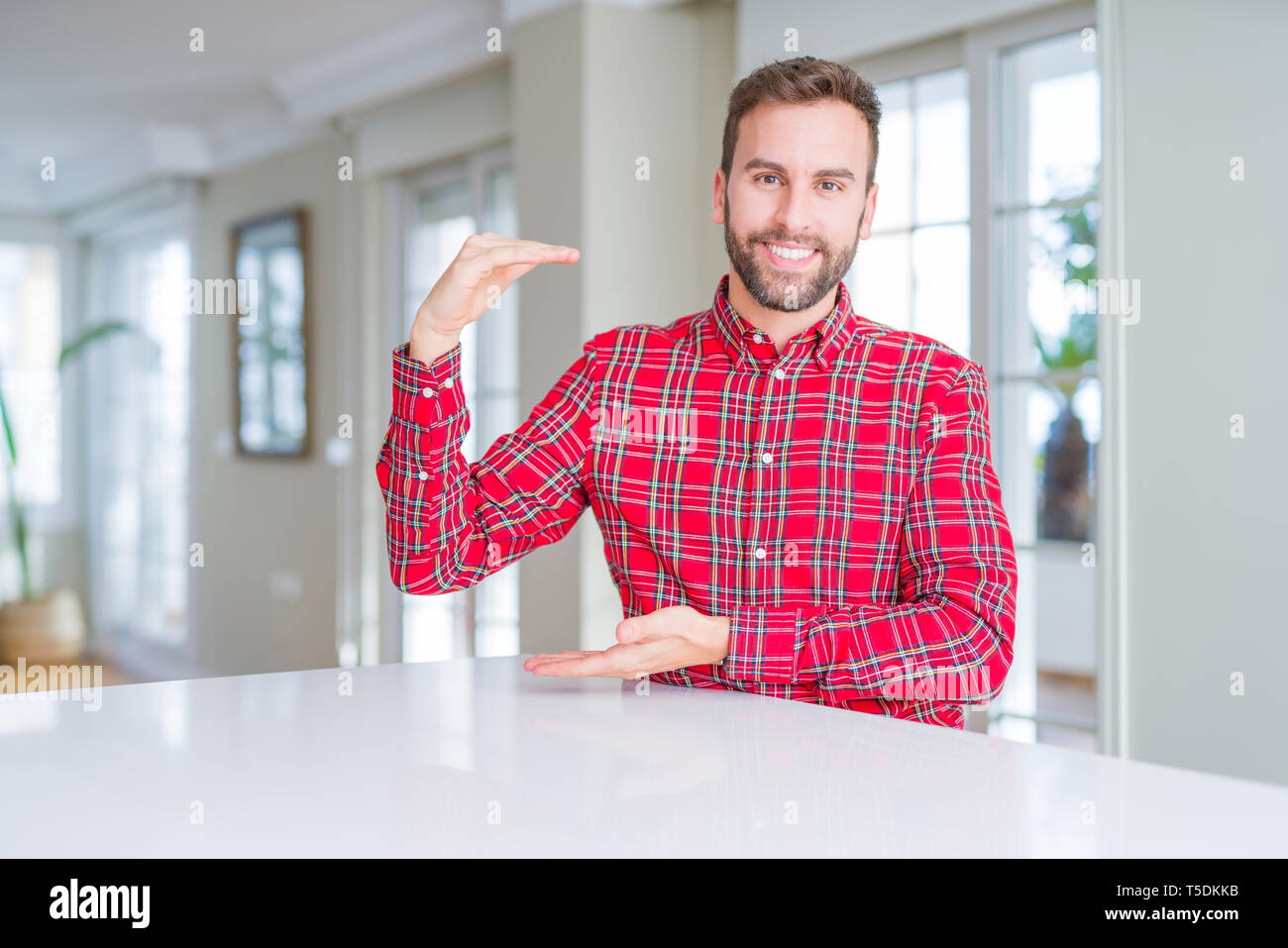 Handsome man wearing colorful shirt gesturing with hands showing big ...