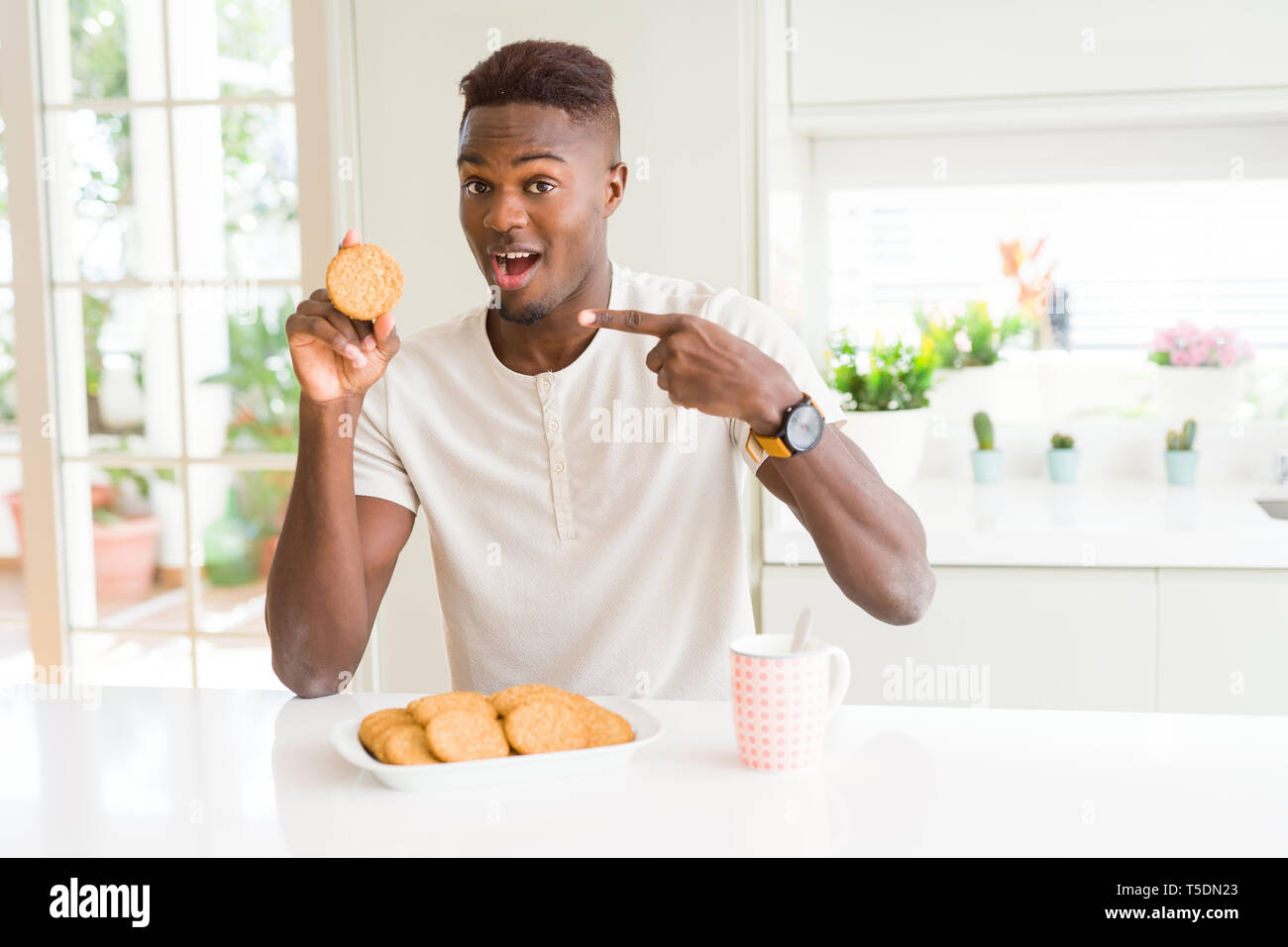 African american man eating healthy whole grain biscuit very happy ...