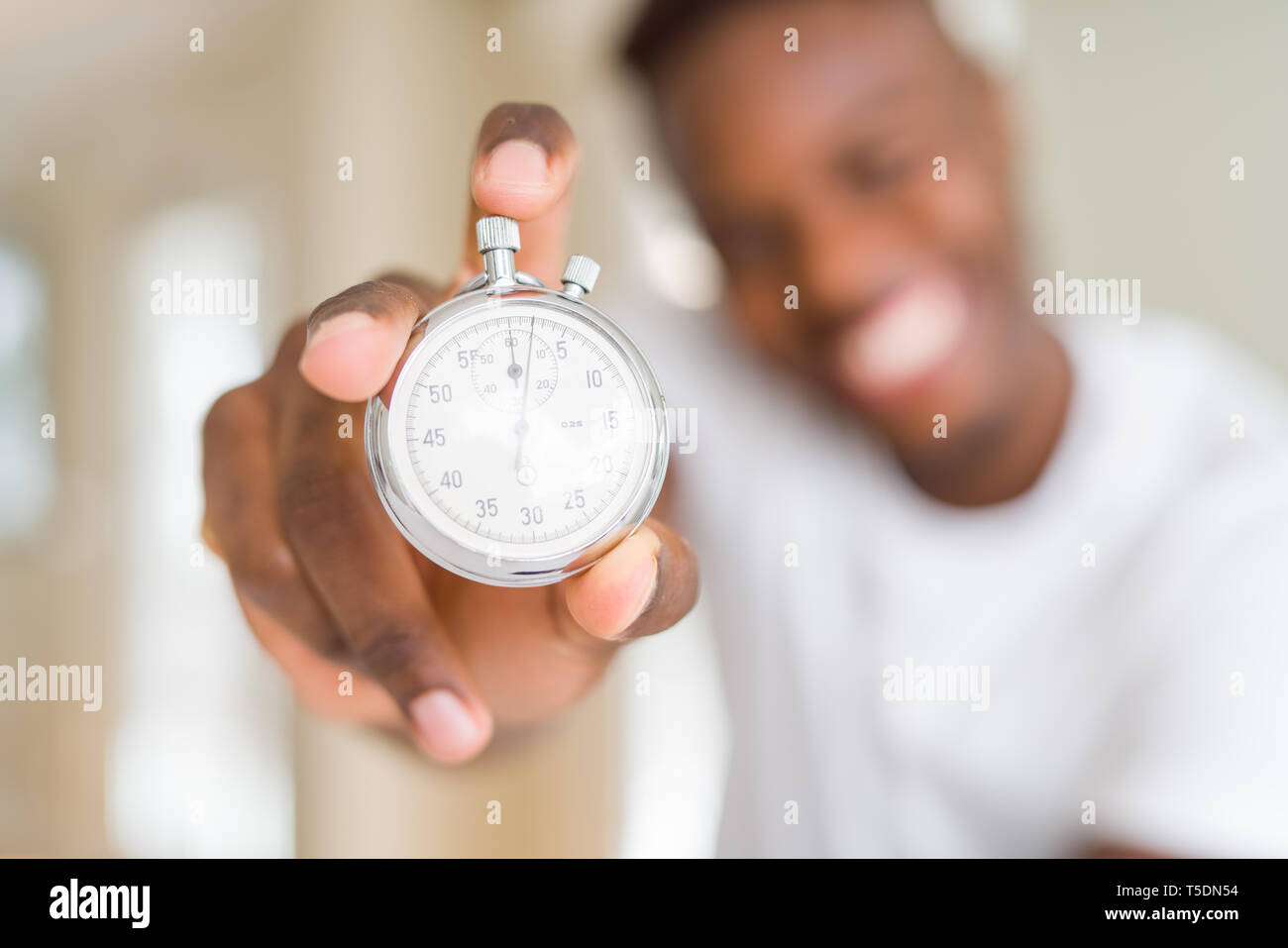 Young african man holding silver retro stopwatch counting time Stock ...