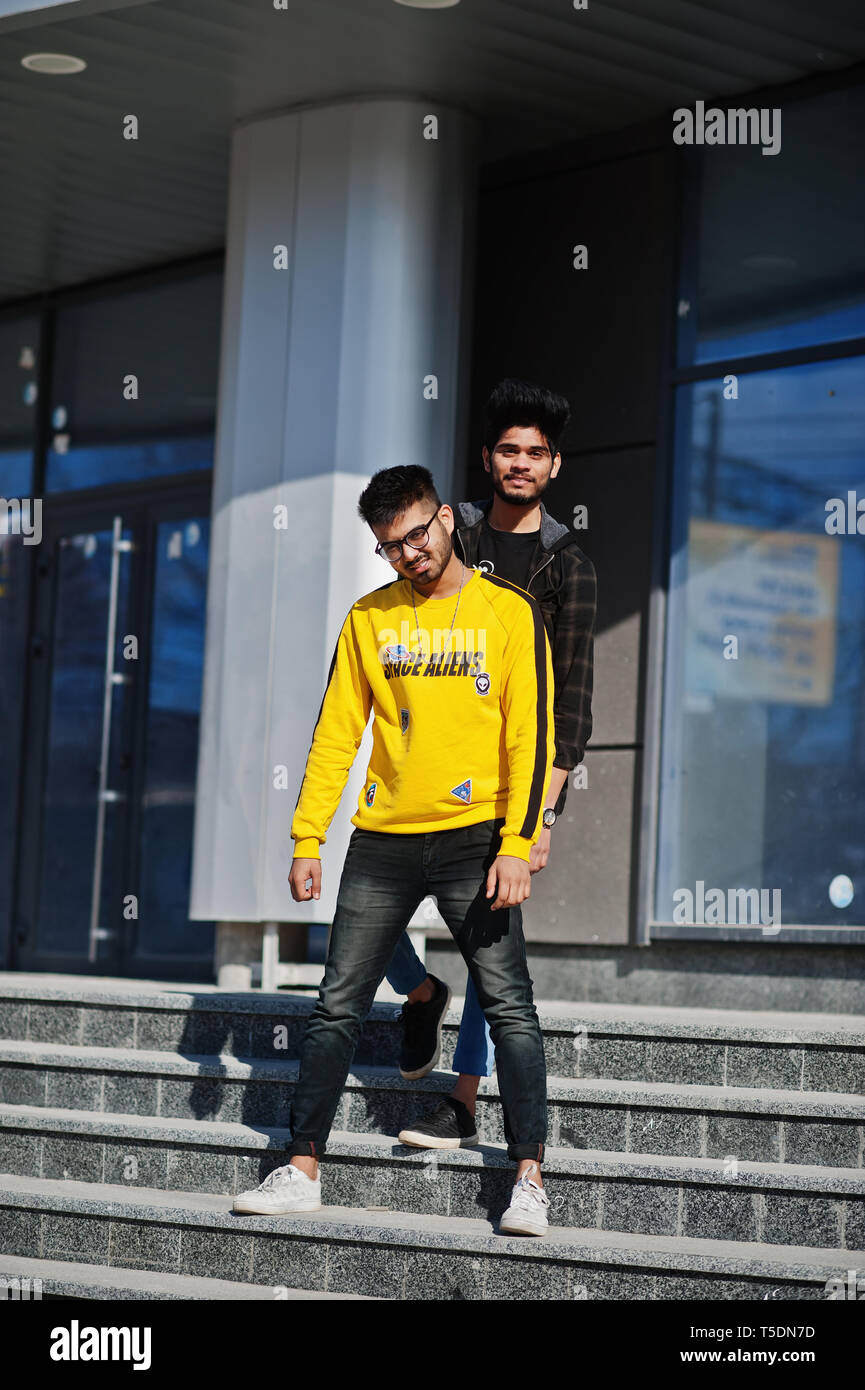 Two asian guys posed against new modern building Stock Photo - Alamy